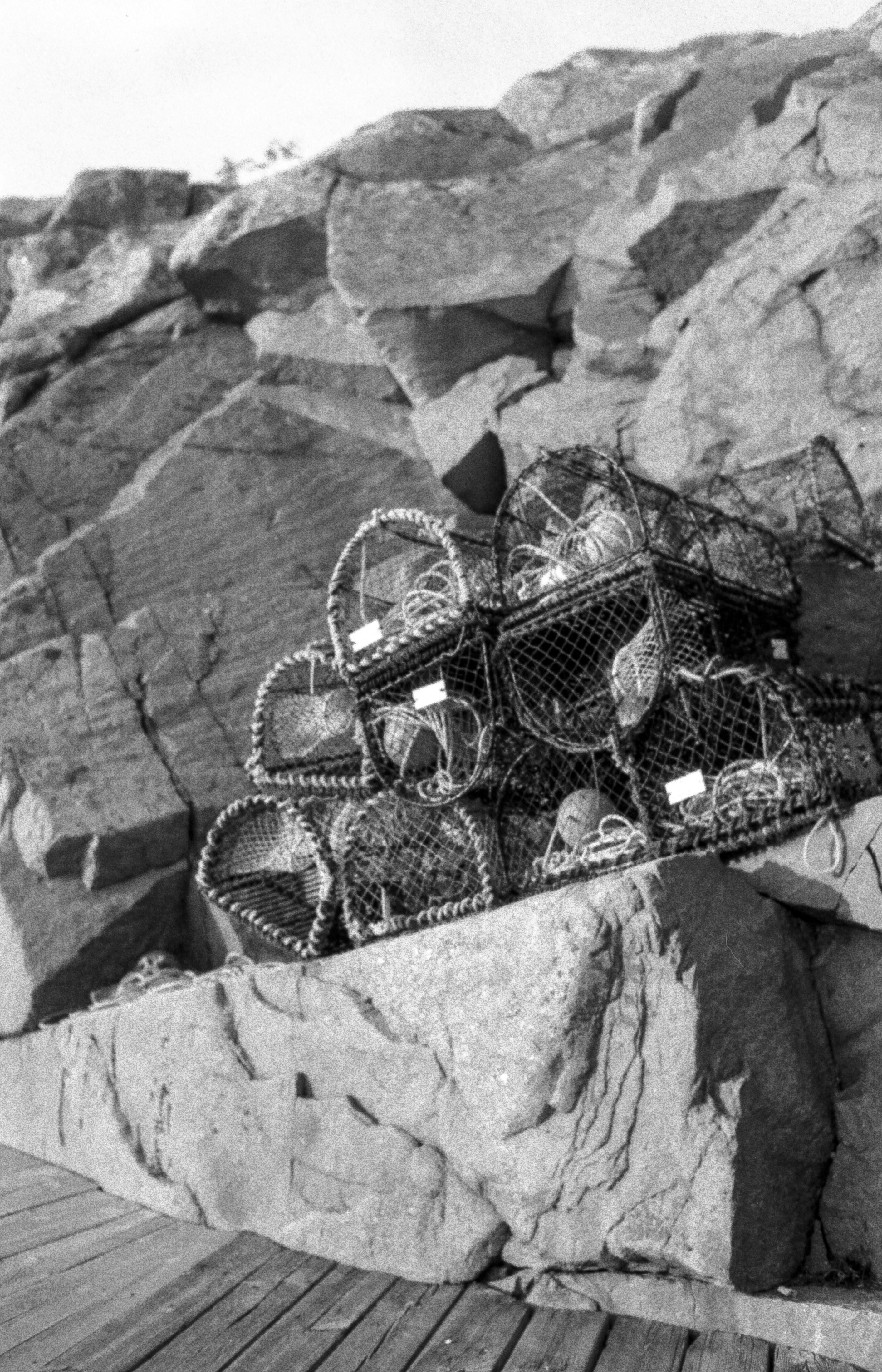 Stack of lobster traps on rocky shore