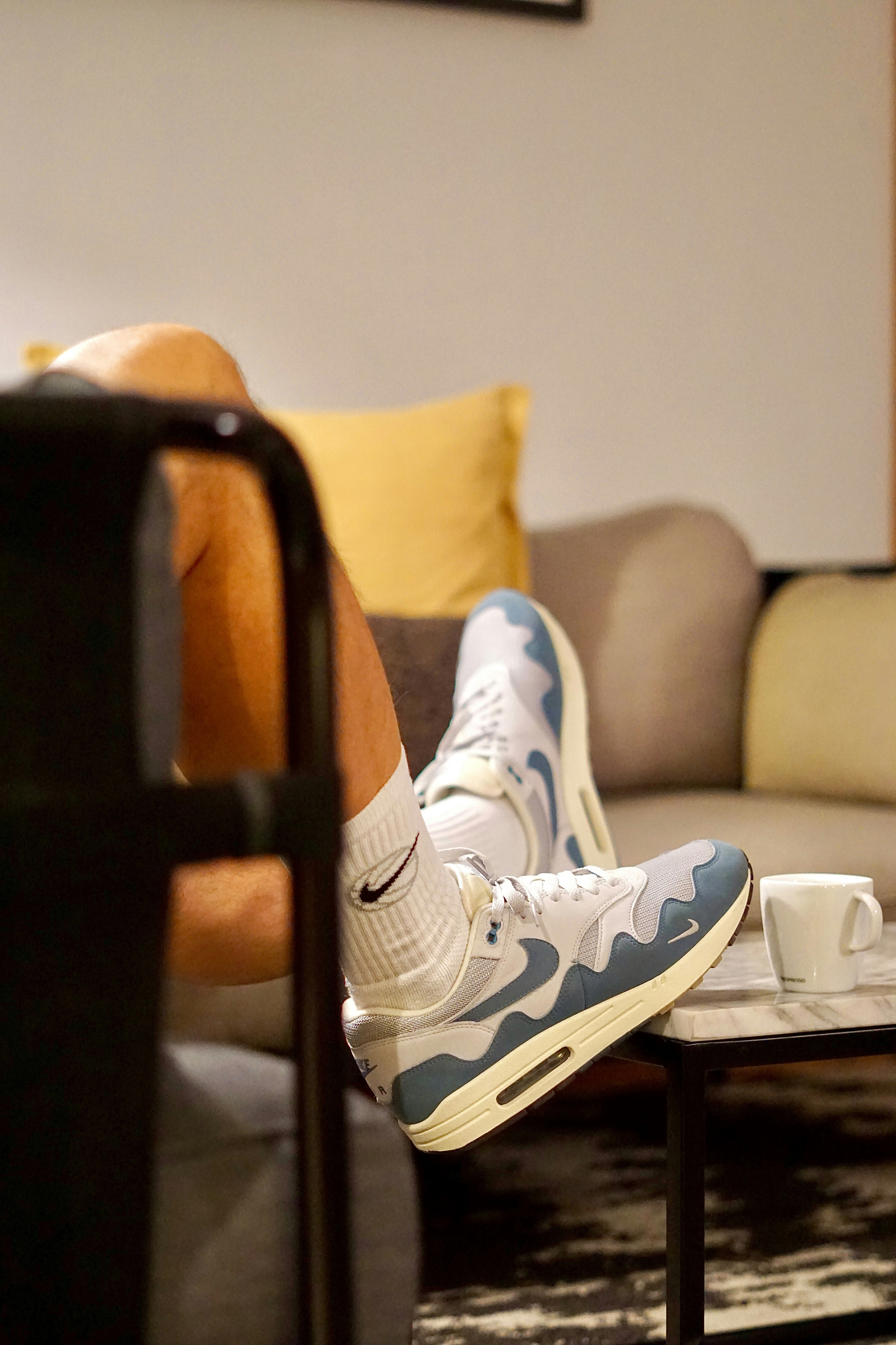 Casual lounge moment: sneaker-clad feet resting on a coffee table