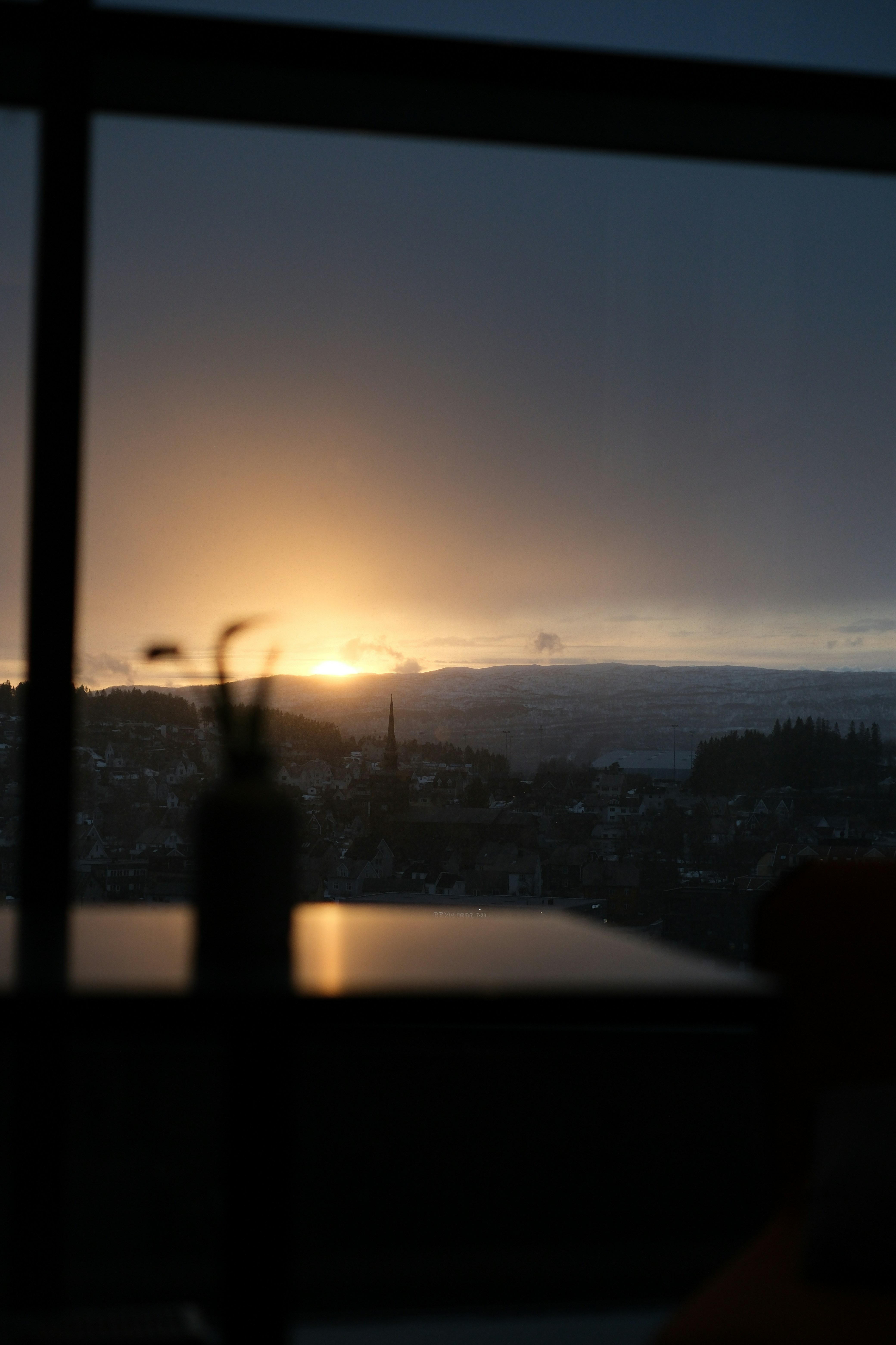 Window to Sunset: City Silhouette Dimming into Twilight