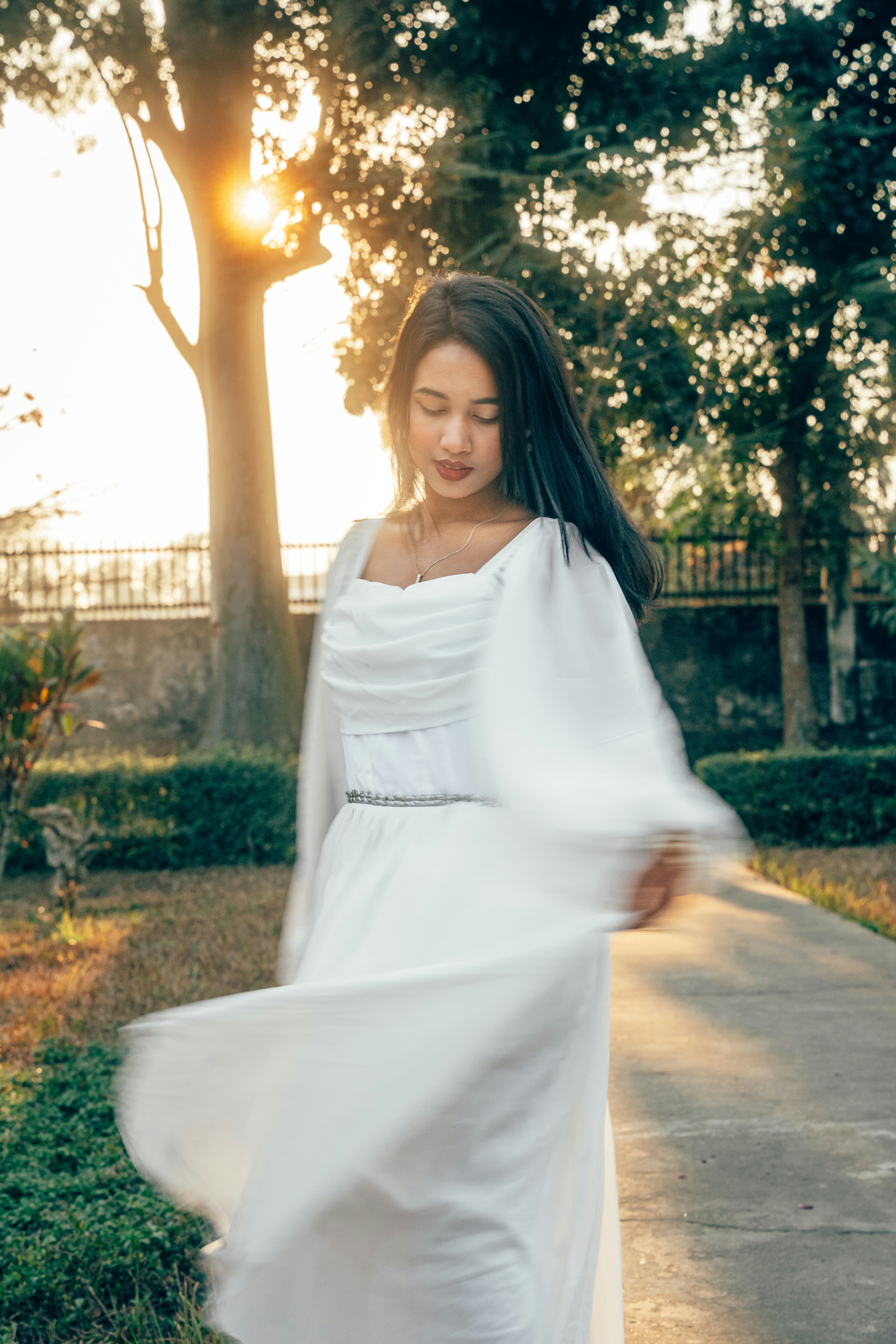 Sunlit Grace: A Portrait in Motion Through a White Dress