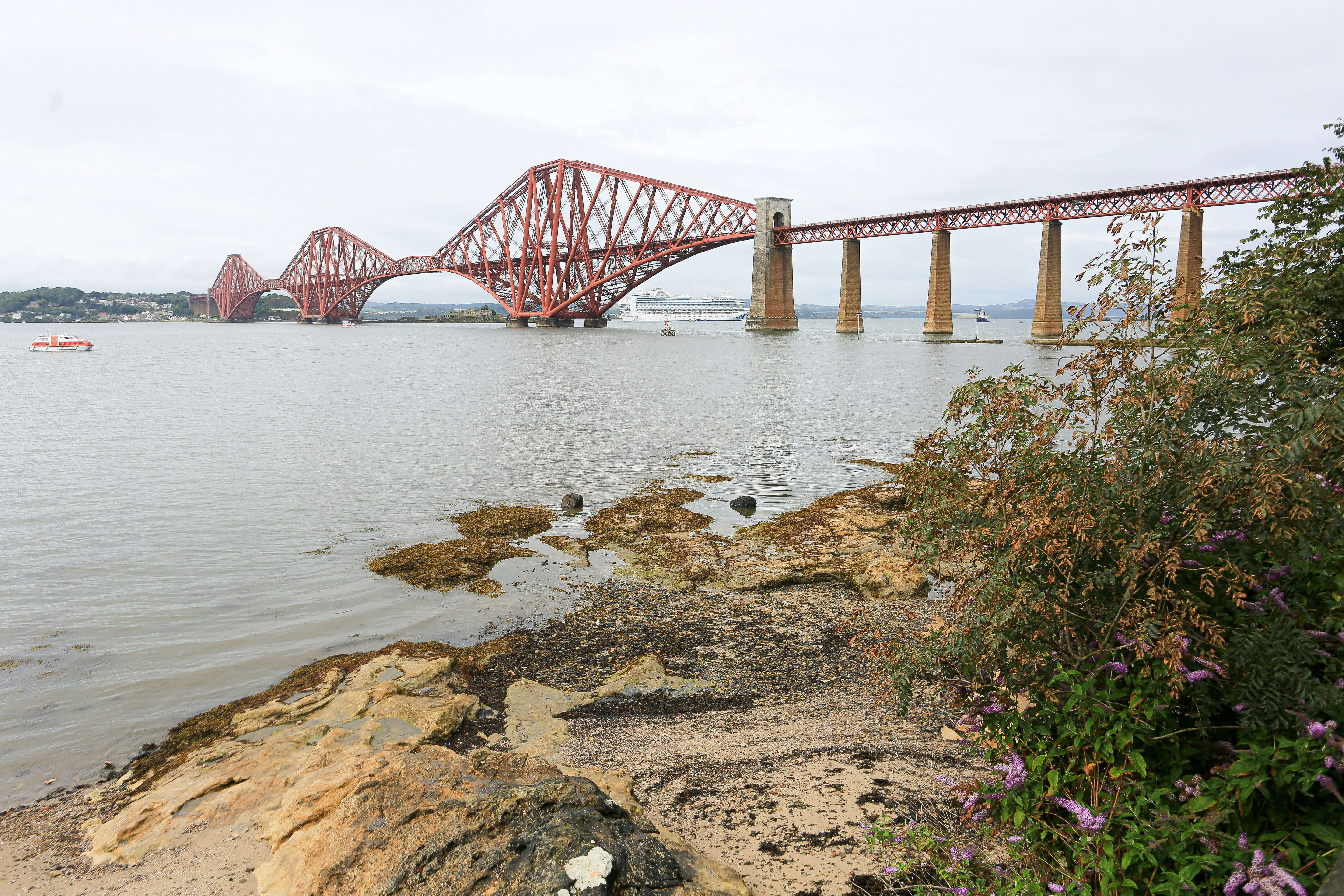 Bridge over Quiet Waters: Ragged Rocks Meet Red Steel