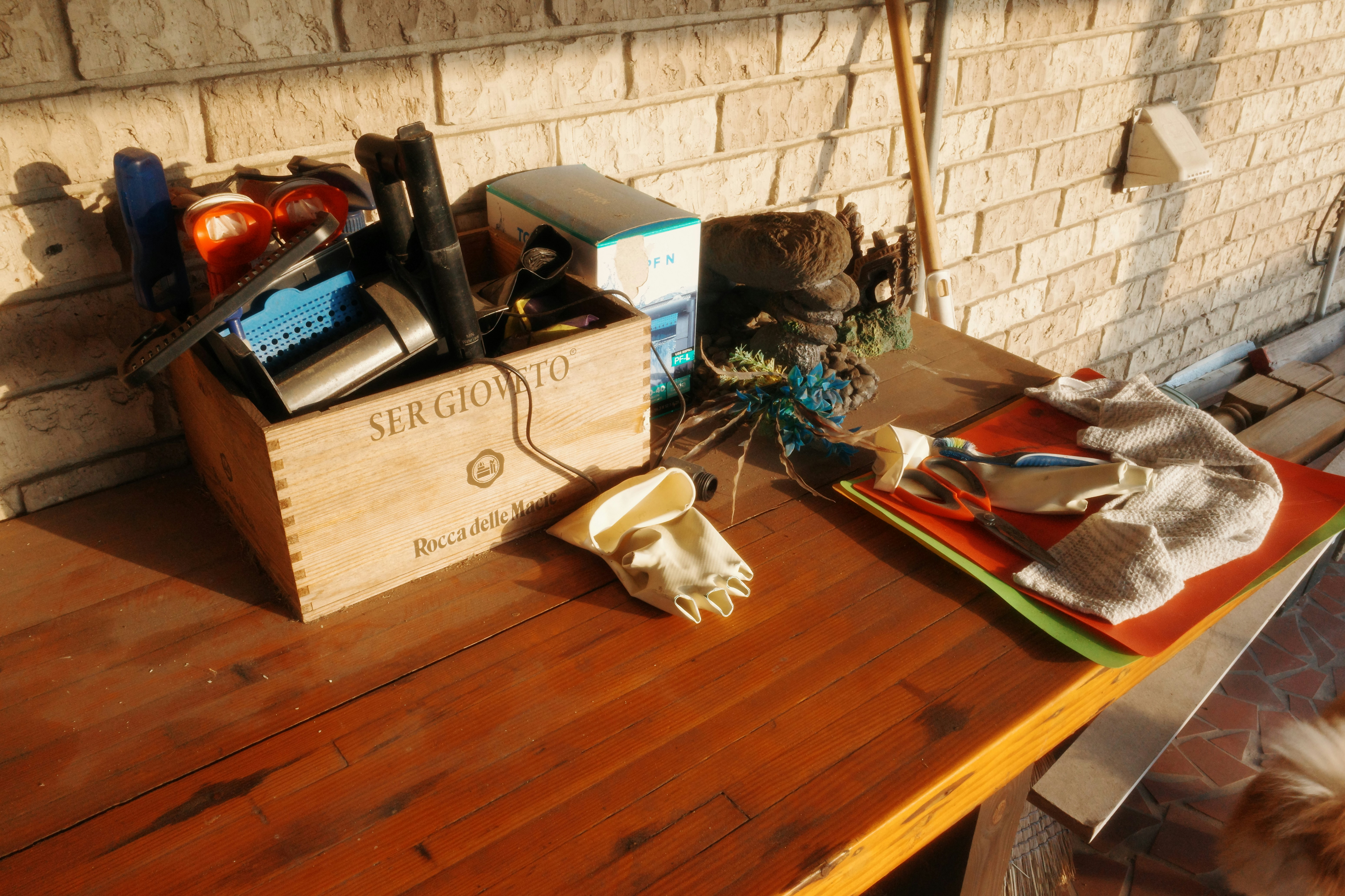 Cluttered Workbench with Tools and Boxed Items in Warm Light