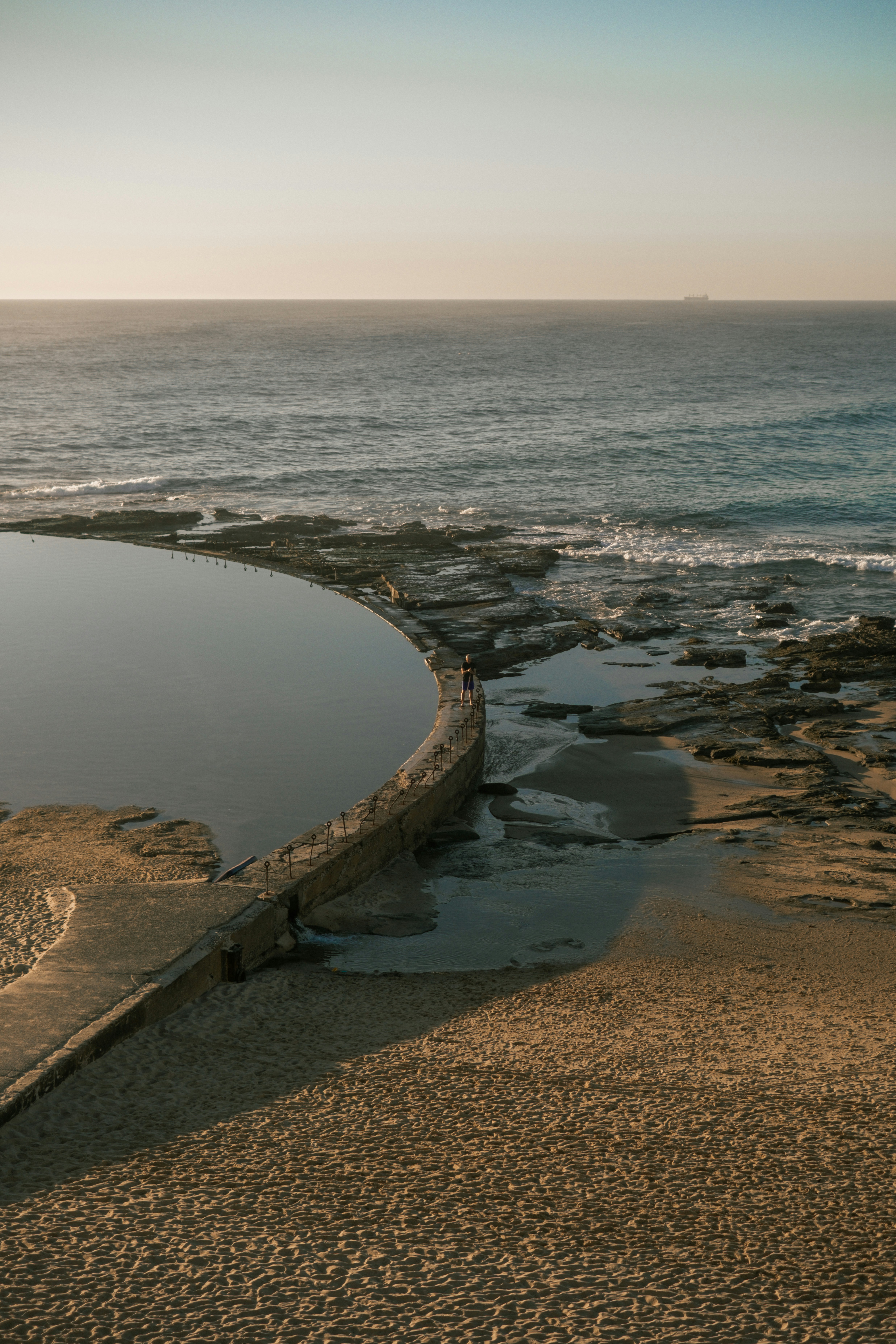 Moonlit Cusp: A Curved Pier Framing the Quiet Sea
