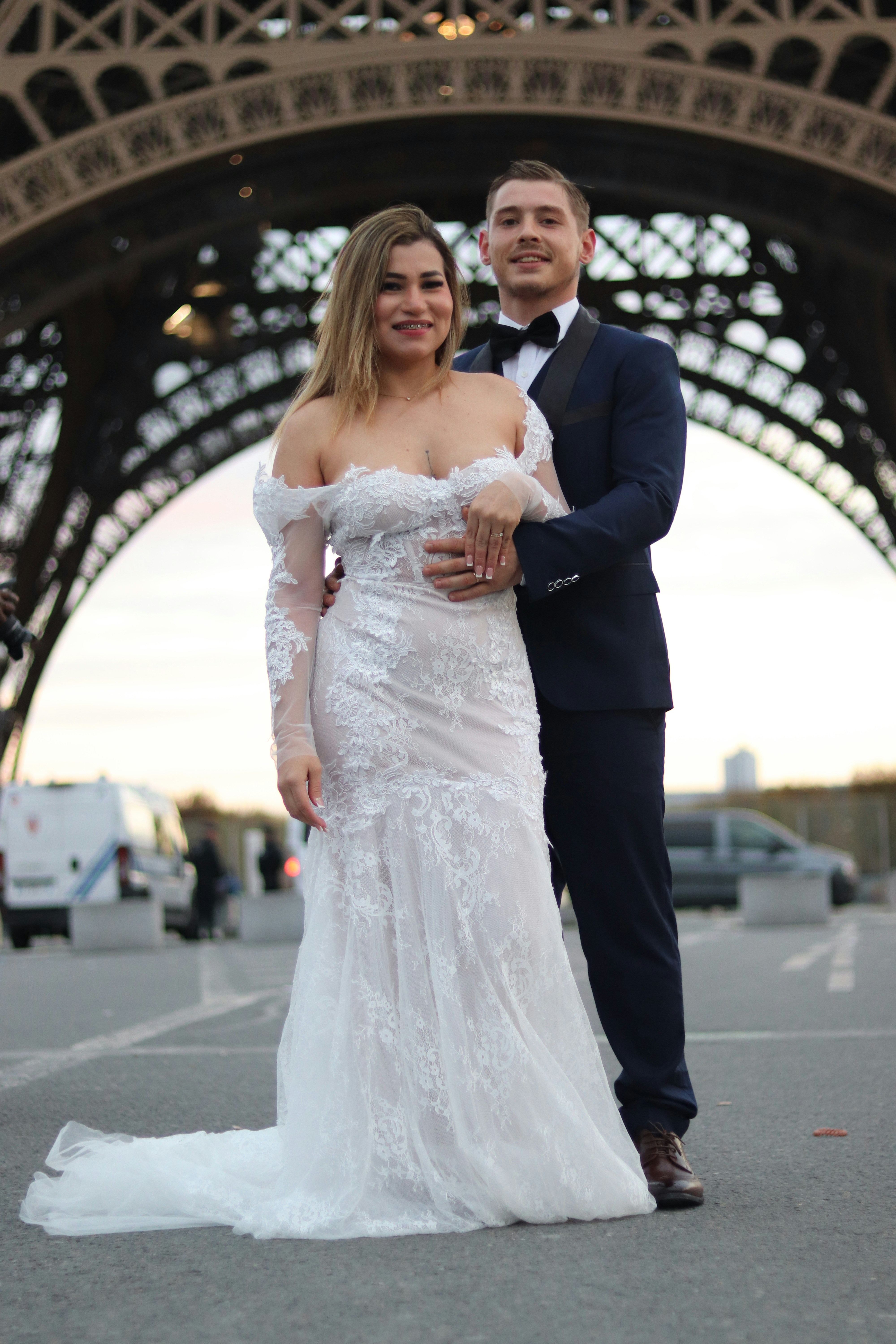 Under the Arc of Romance: Bride and Groom Embrace Beneath the Eiffel-inspired Structure