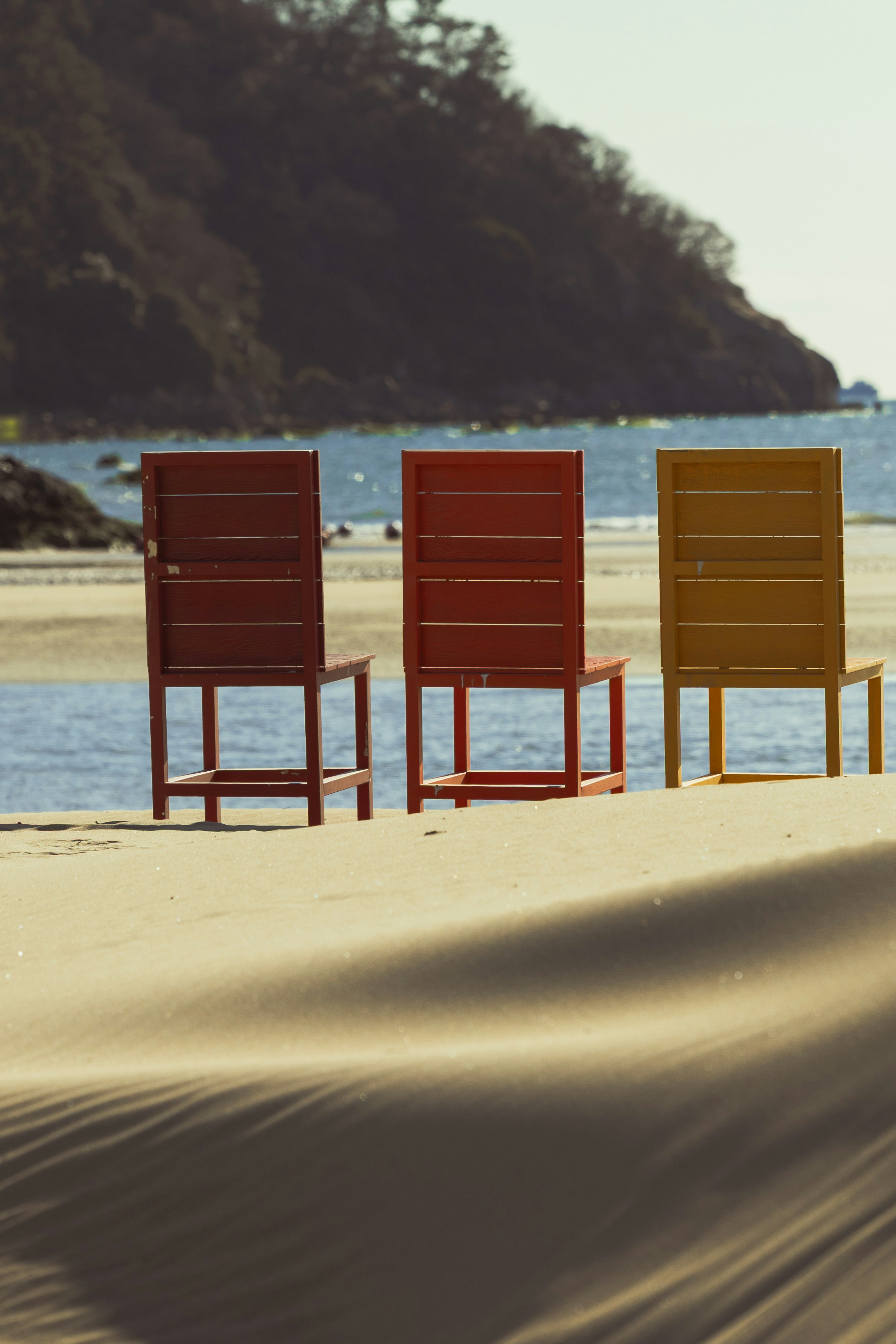 Three Chairs on Sunlit Beach: A Trio of Color and Calm