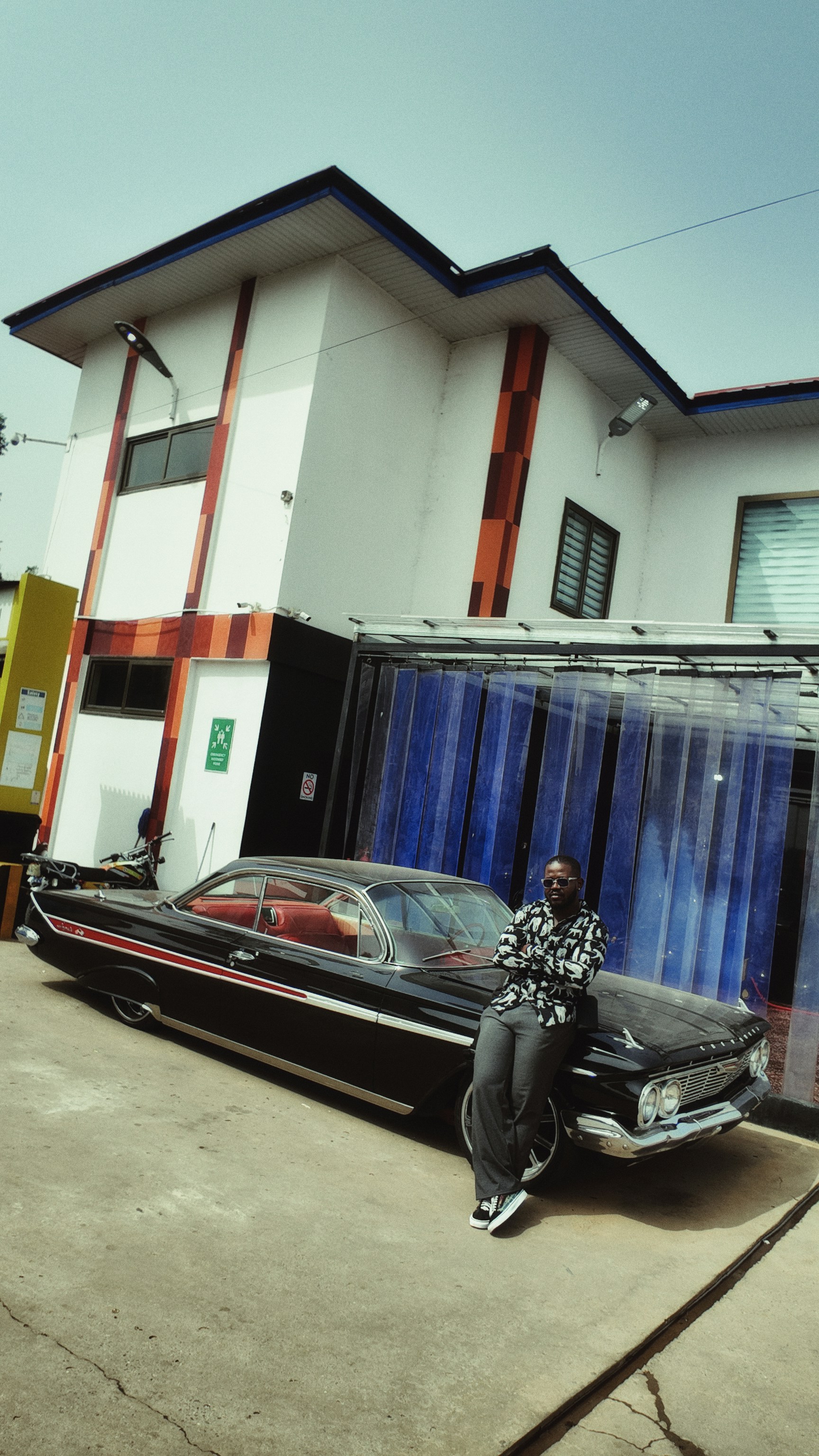 Man leans against a vintage black car