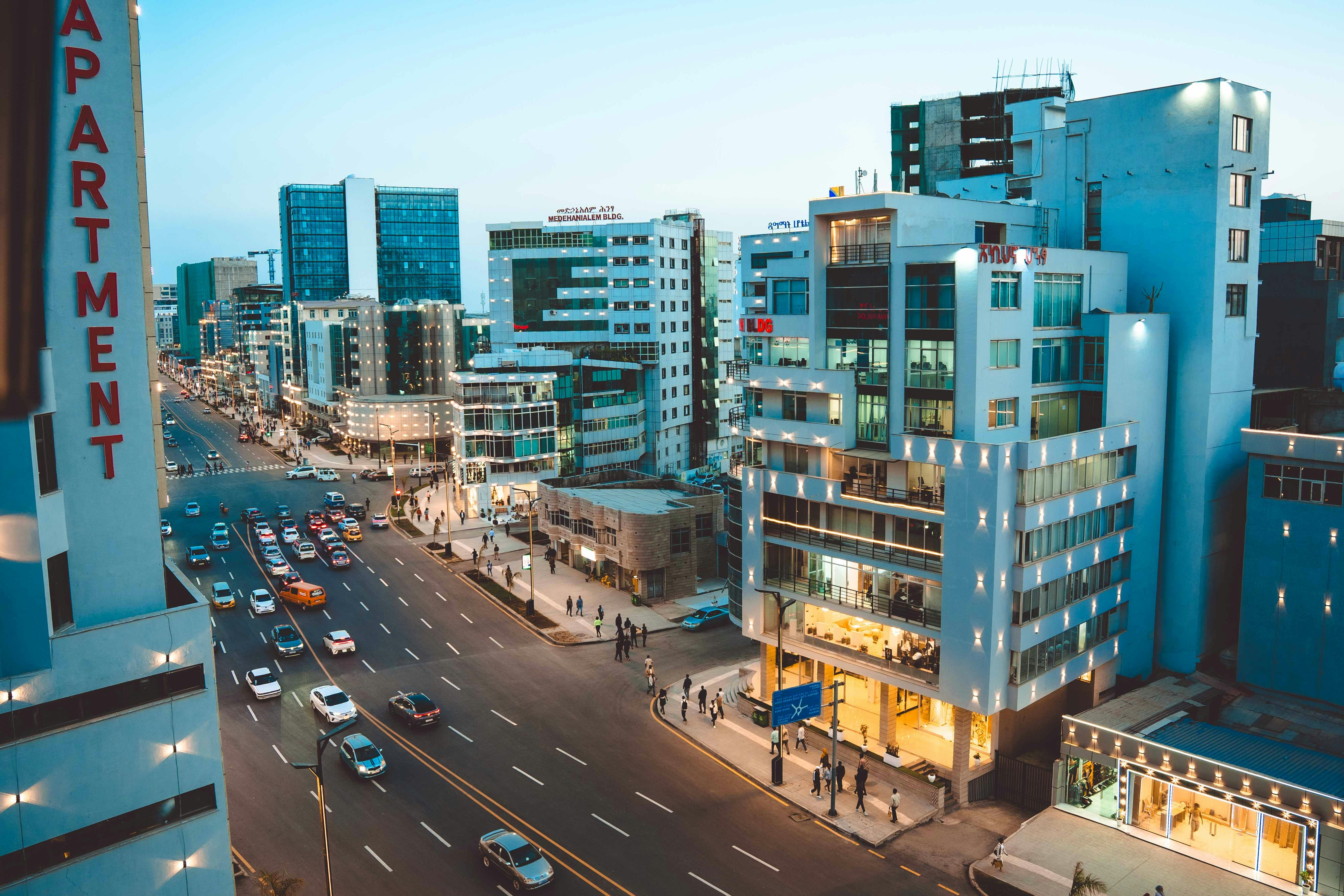 Busy city street with cars and tall buildings at dusk