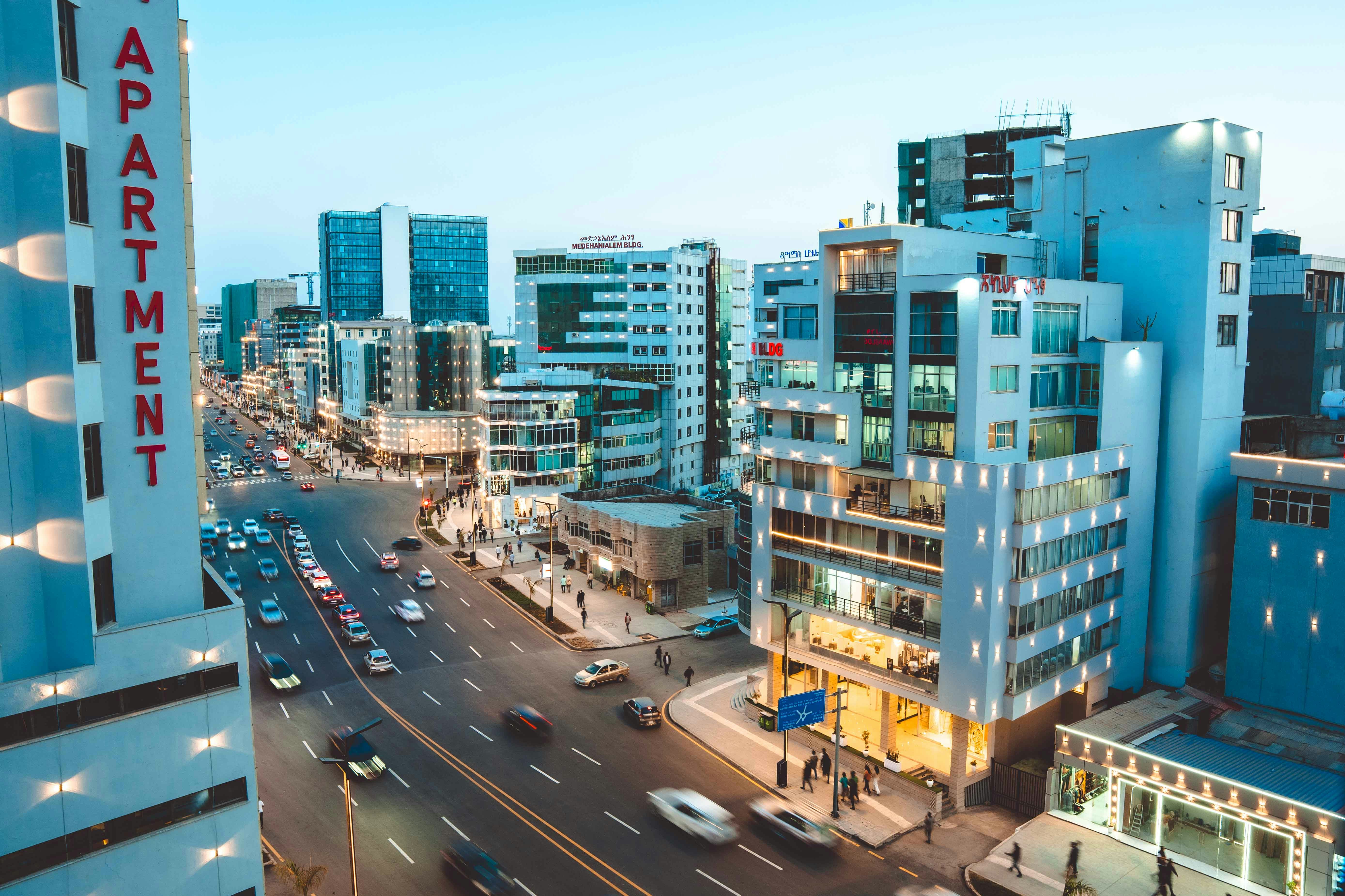 Busy city street with cars and tall buildings at dusk