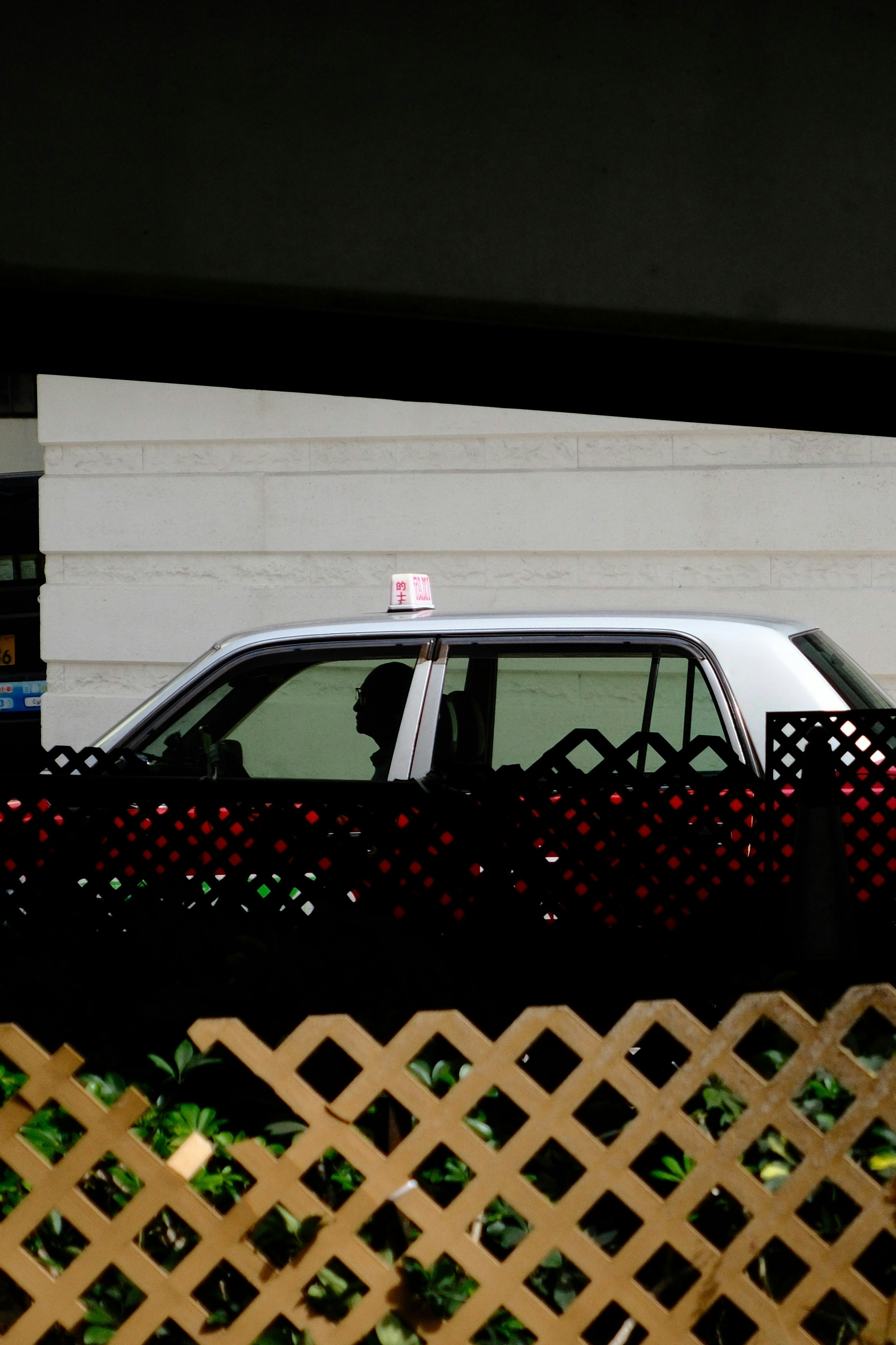 Taxi Roof Silhouette: Car Window Reflections Behind Lattice