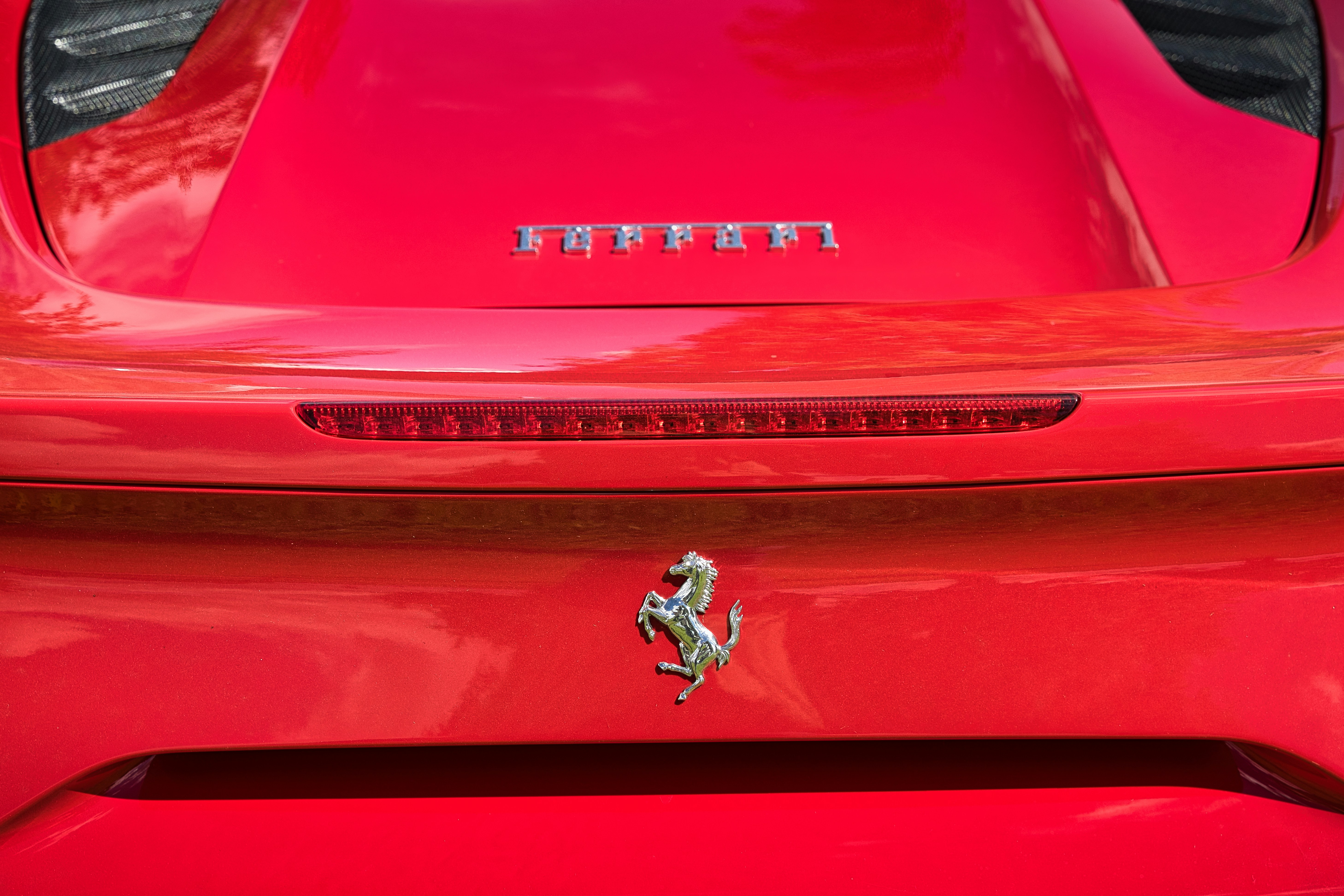 Chrome Stallion in Red: The Ferrari Badge Above a Pristine Trunk