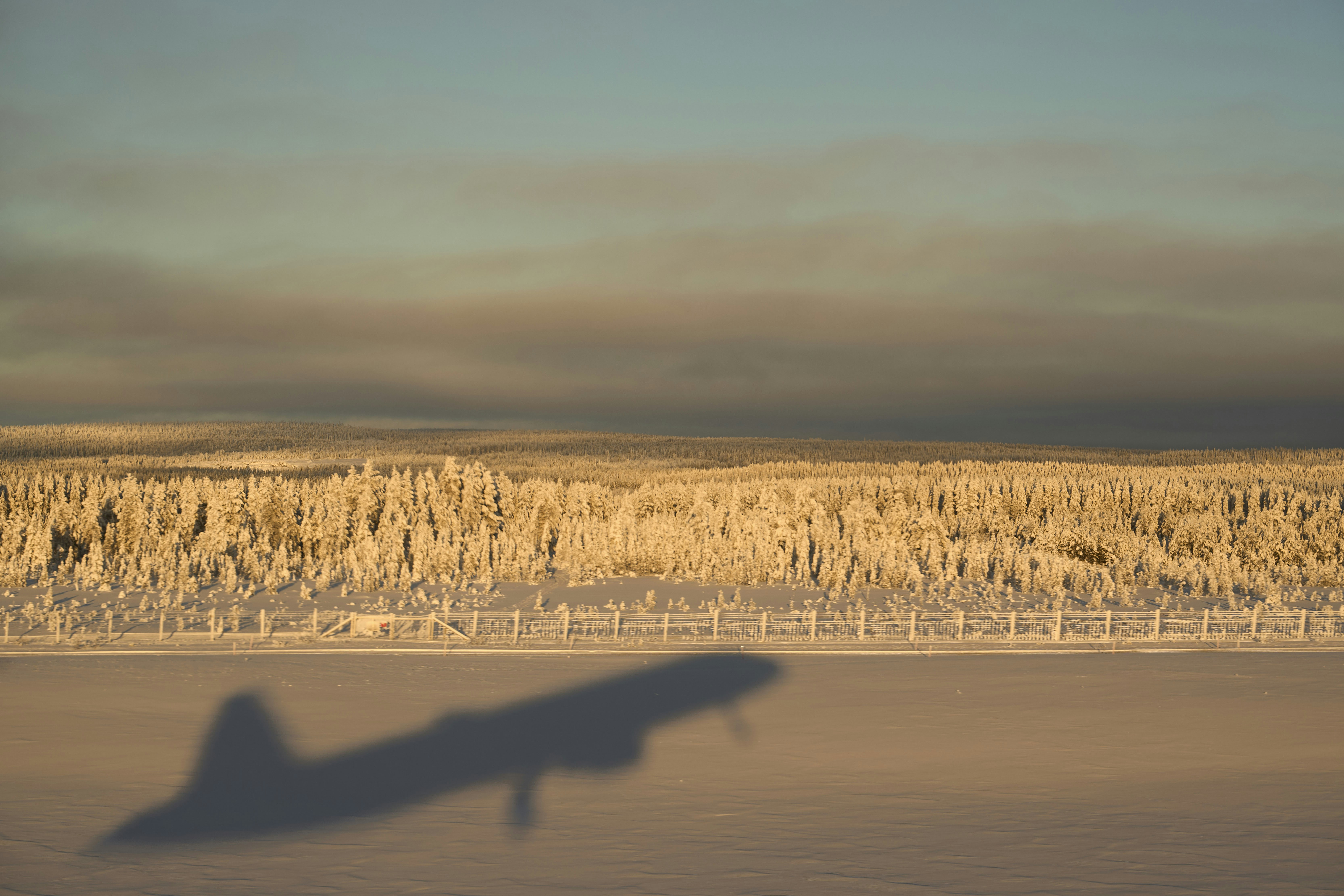 Shadowed Takeoff Over Snowfield