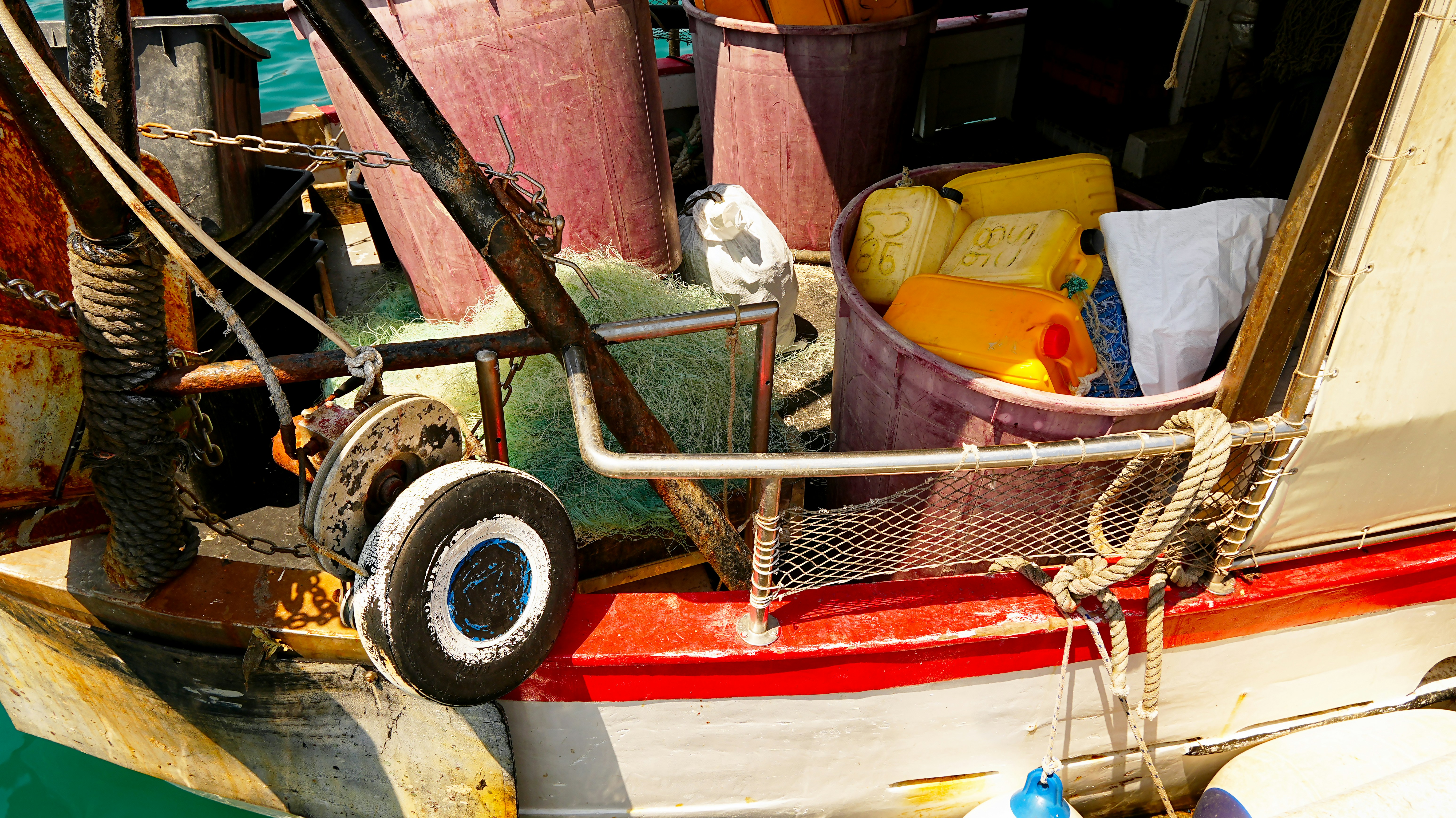 Red-Trimmed Hull and Sunlit Gear: A Colorful Dockside Scene
