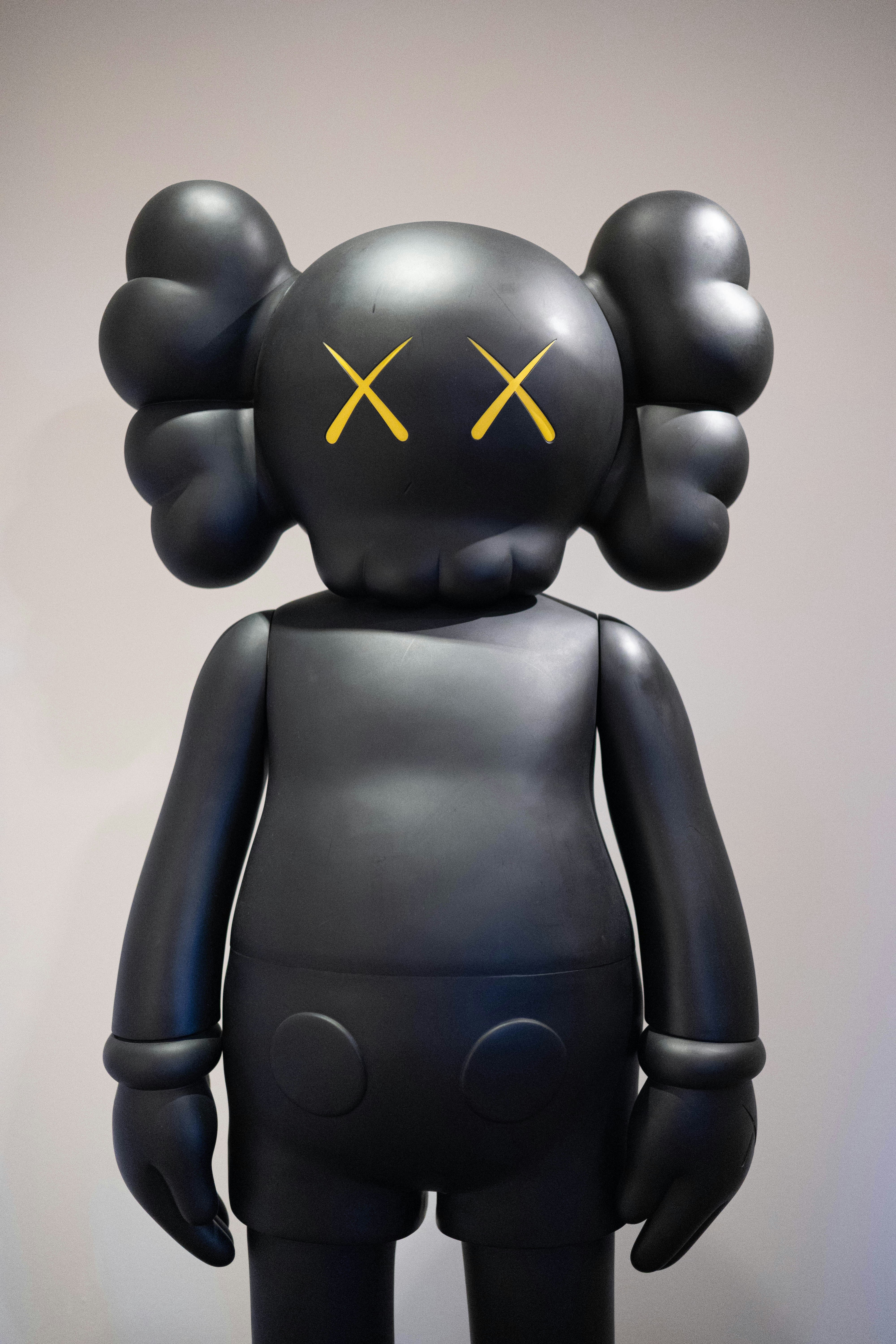 Kaws-inspired vinyl figure with X-eyed face in a museum vignette