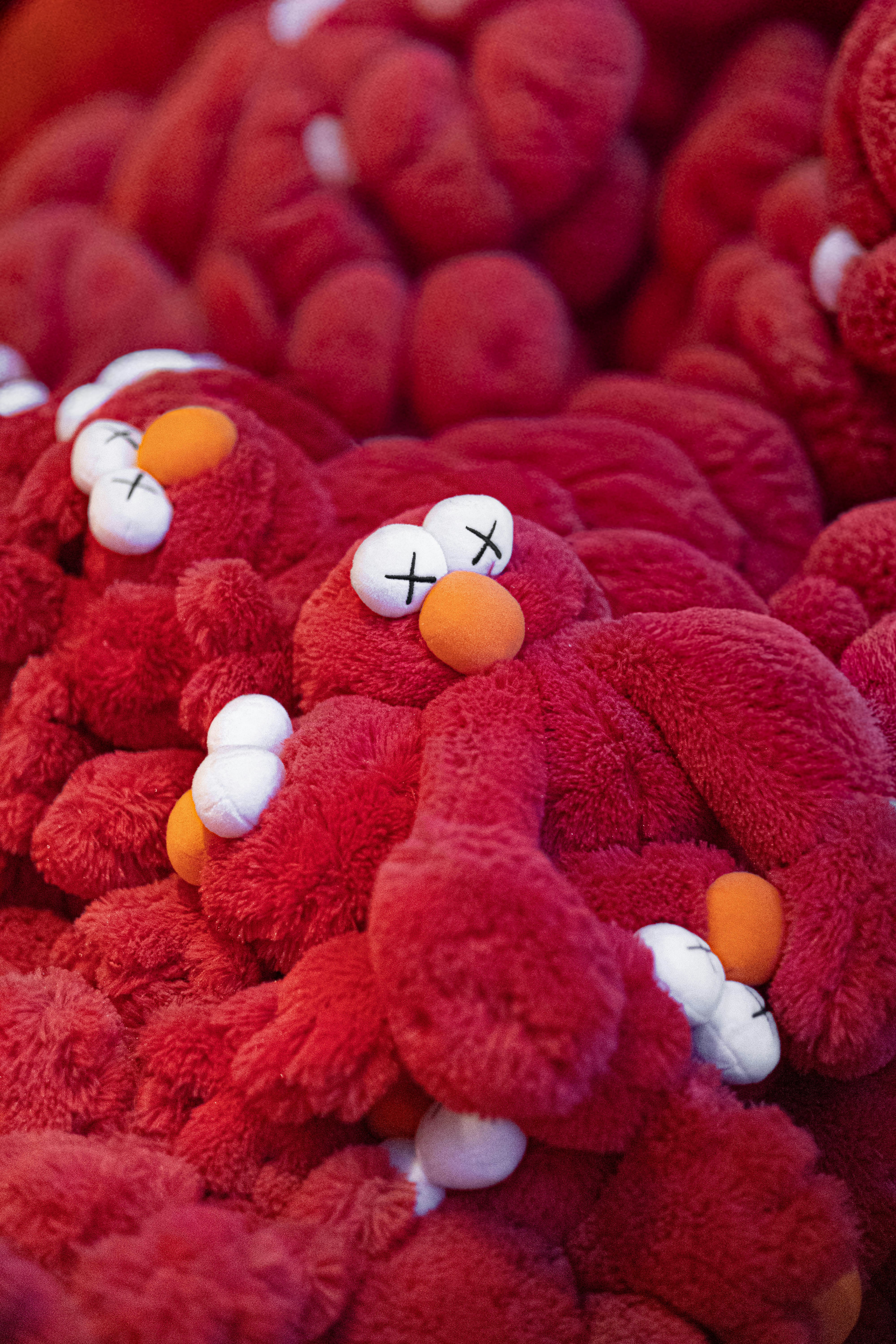 Crimson Plush Faces with X'd Eyes in a Sea of Soft Mirth