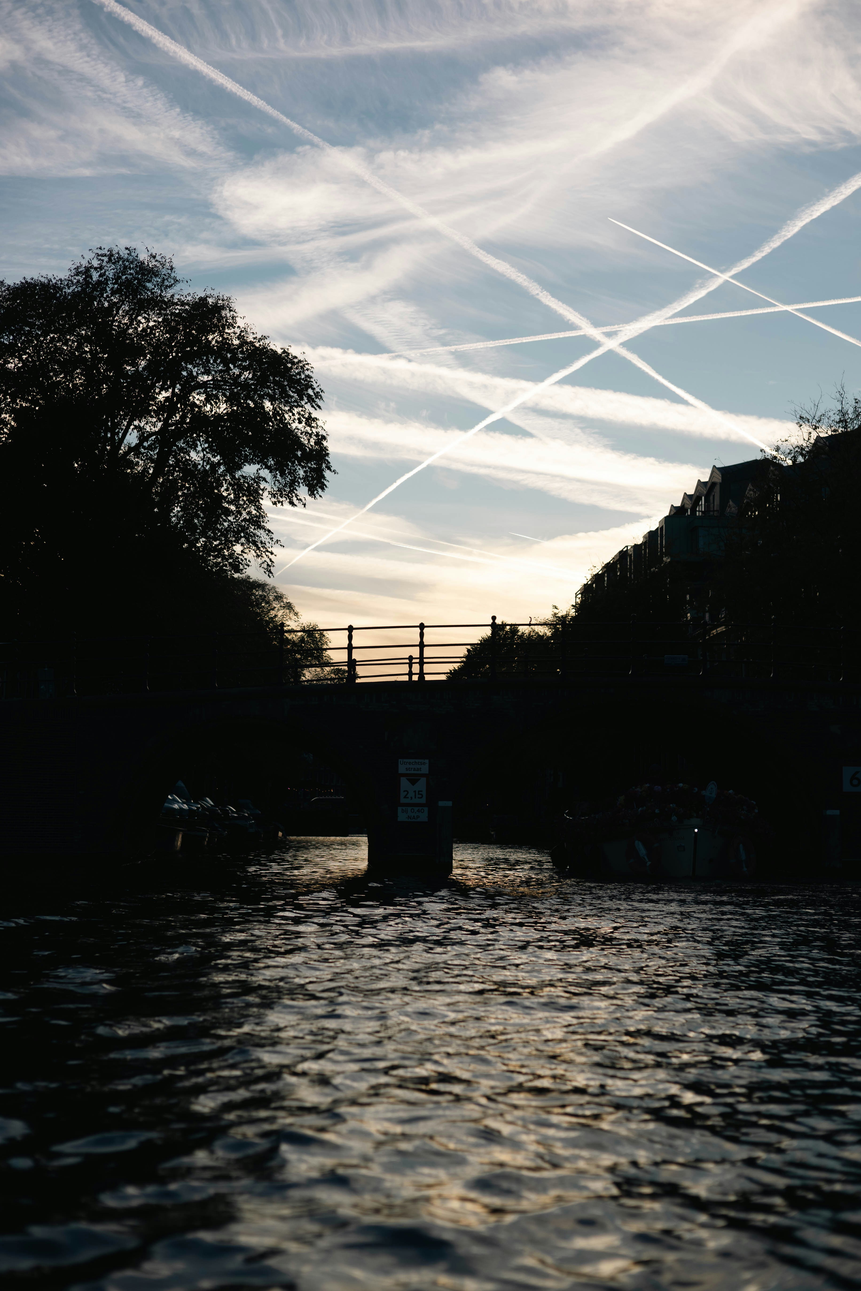 Crossed Trails Over a Quiet Canal at Dusk