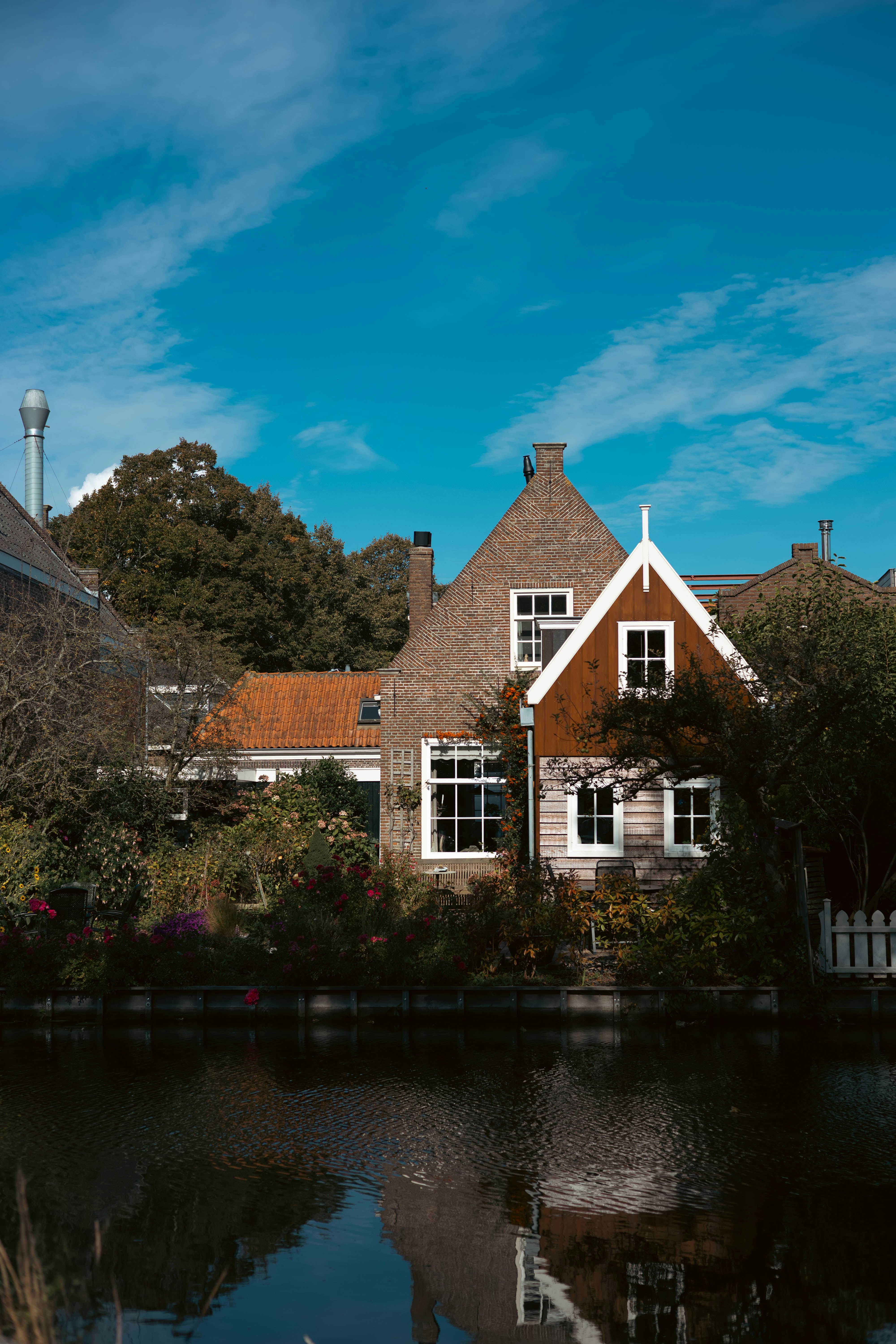Canal-side Home with White Gable Trim Reflecting on Still Water