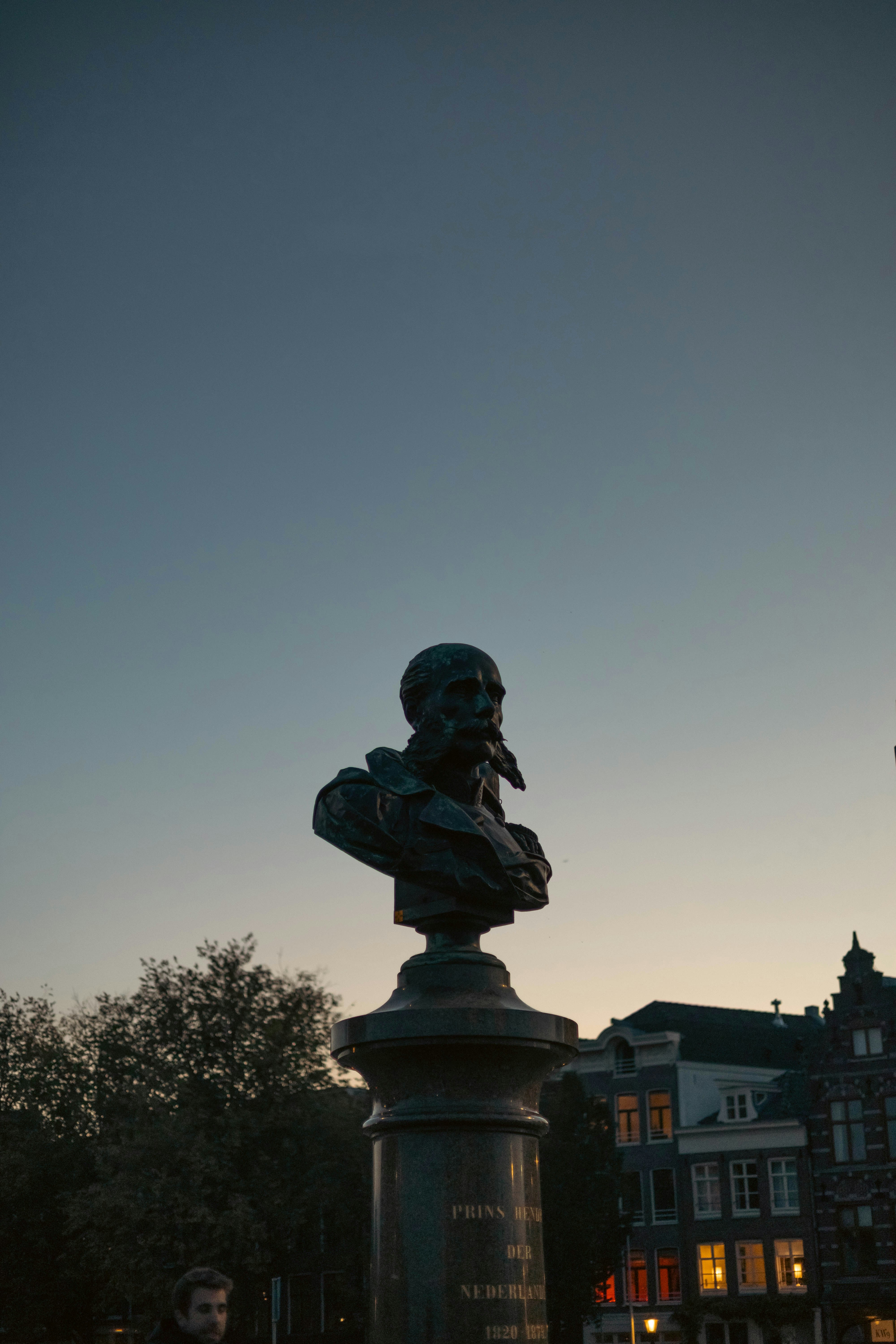 Bronze Figure at Dusk: A Quiet City Standstill
