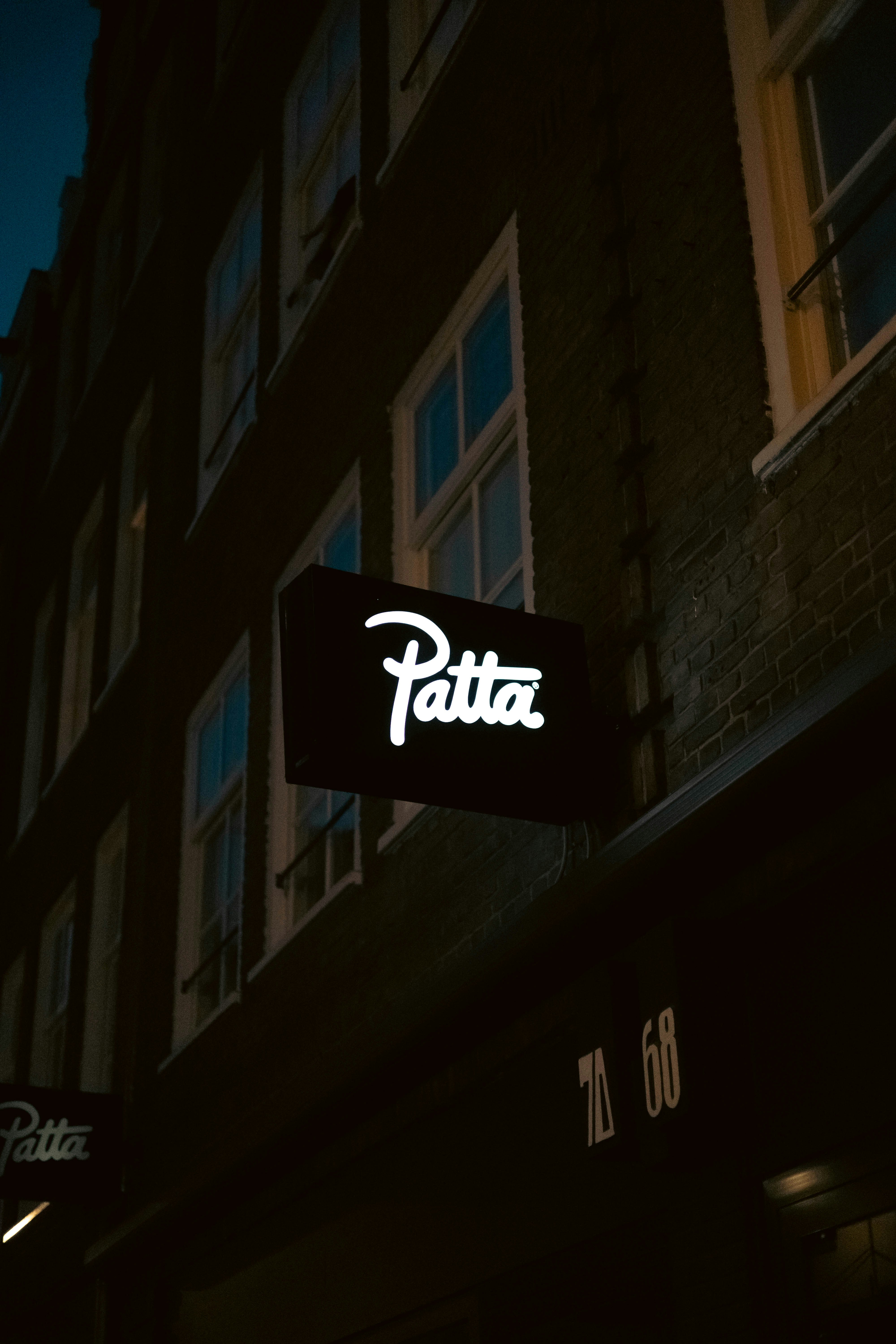 Neon Patta Sign Illuminates a Quiet Street Face