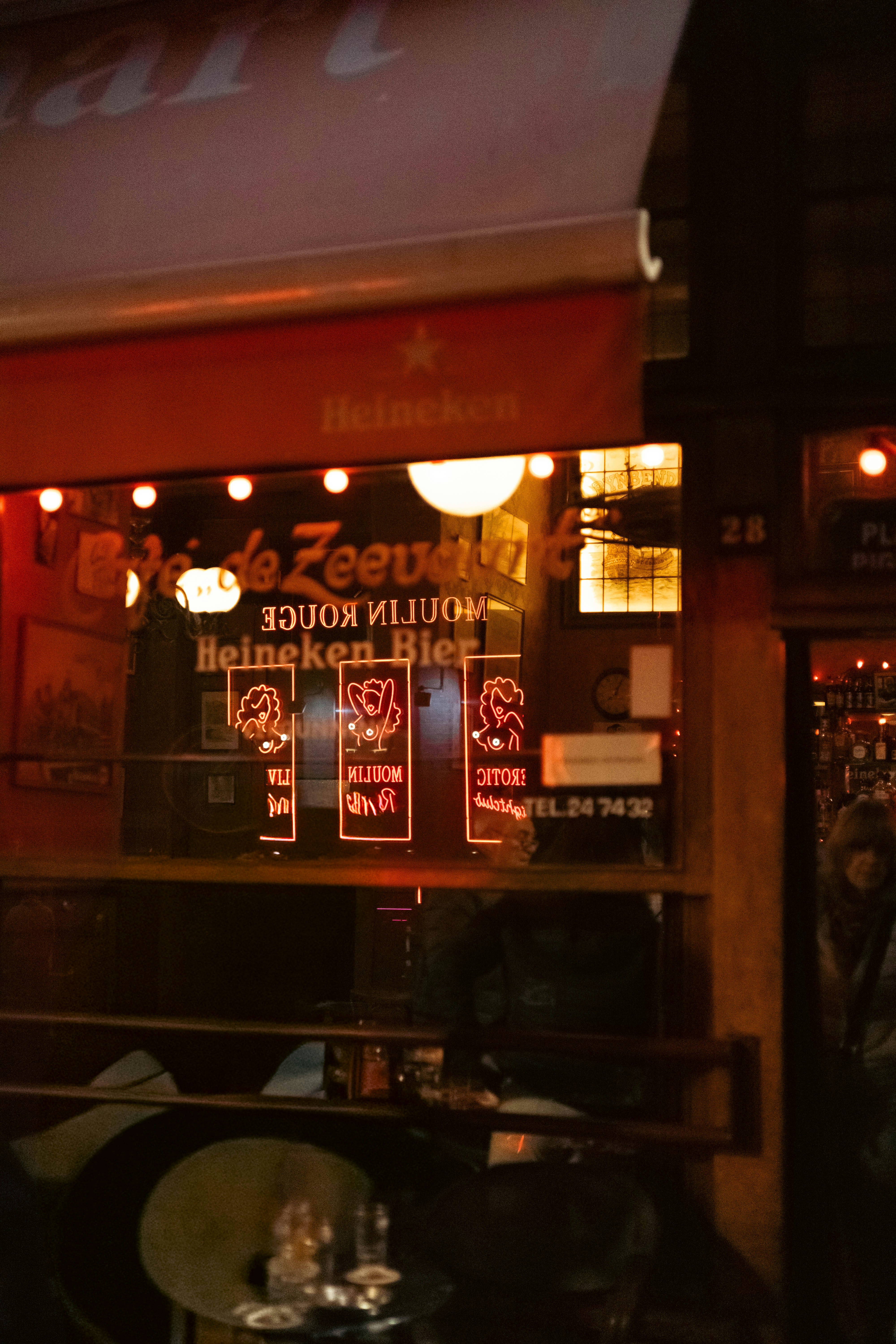 Neon Reflections on a Night-lit Café Window