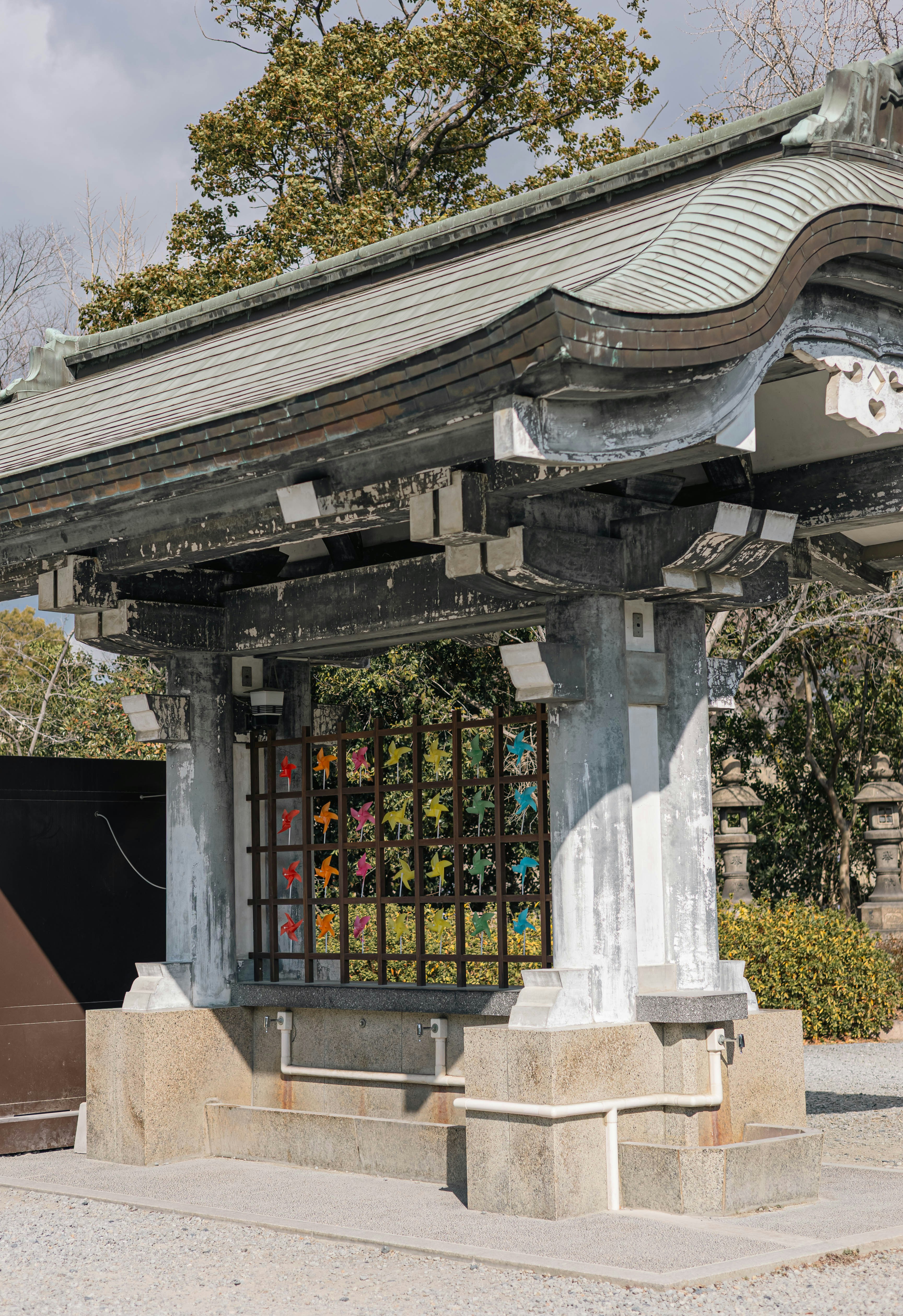 Temple Kiosk Under Curved Roof: Sunlit Stonework and Leafy Dappled Backdrop