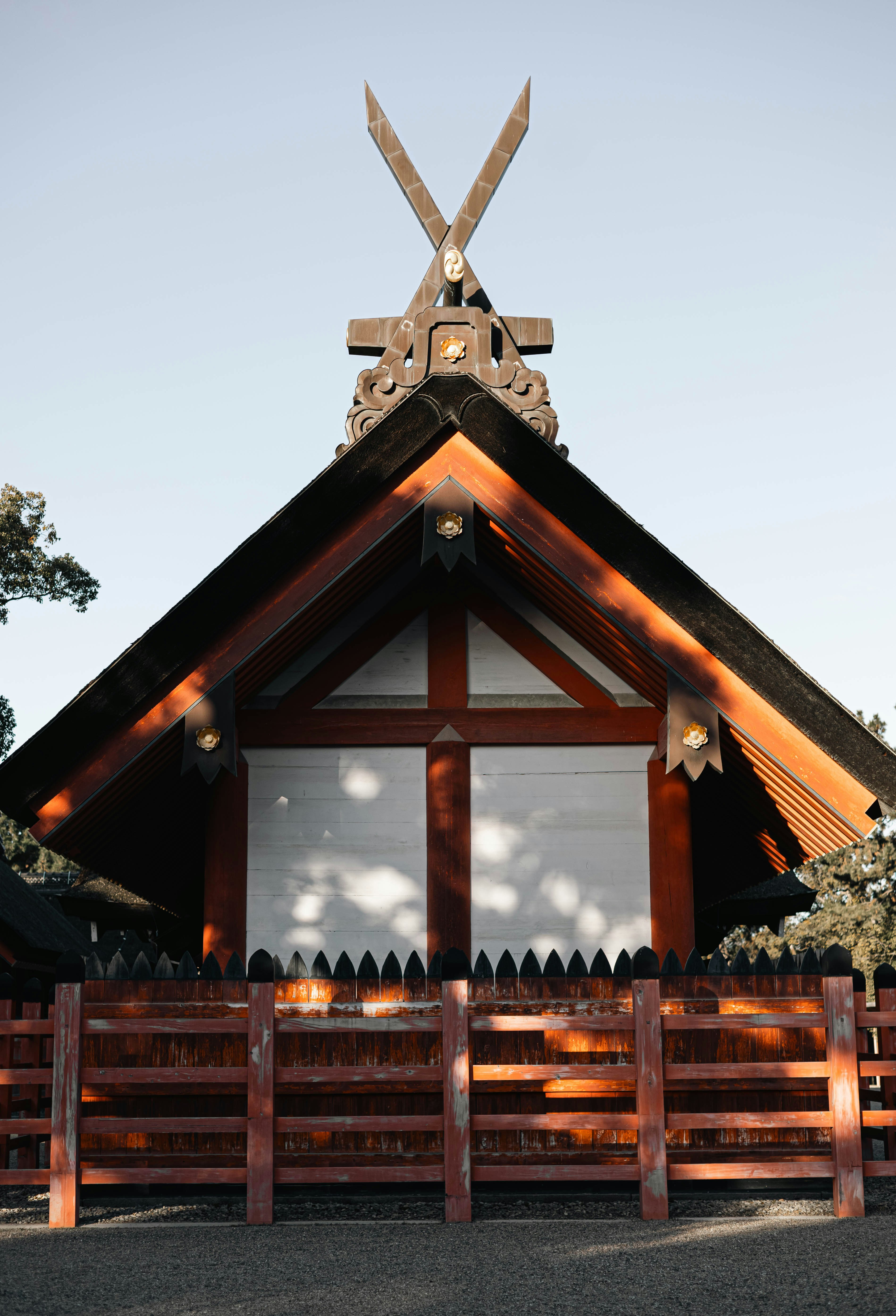 Rising Roofline: A Shinto Shrine Gable Framed by Red Timber and Upright Crossed Ornaments