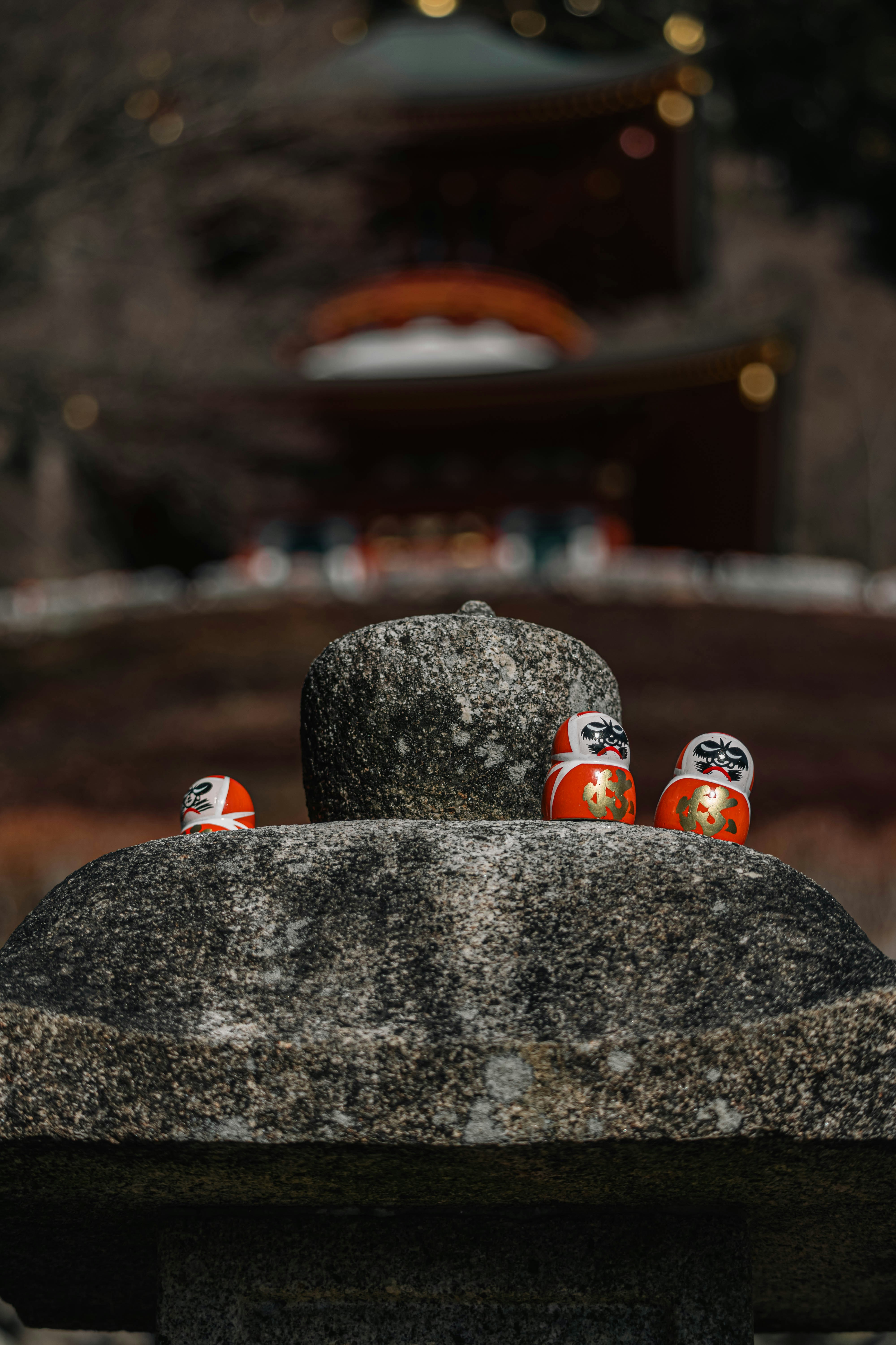 Knot of Stones: Daruma Figures Framing a Sacred Stone