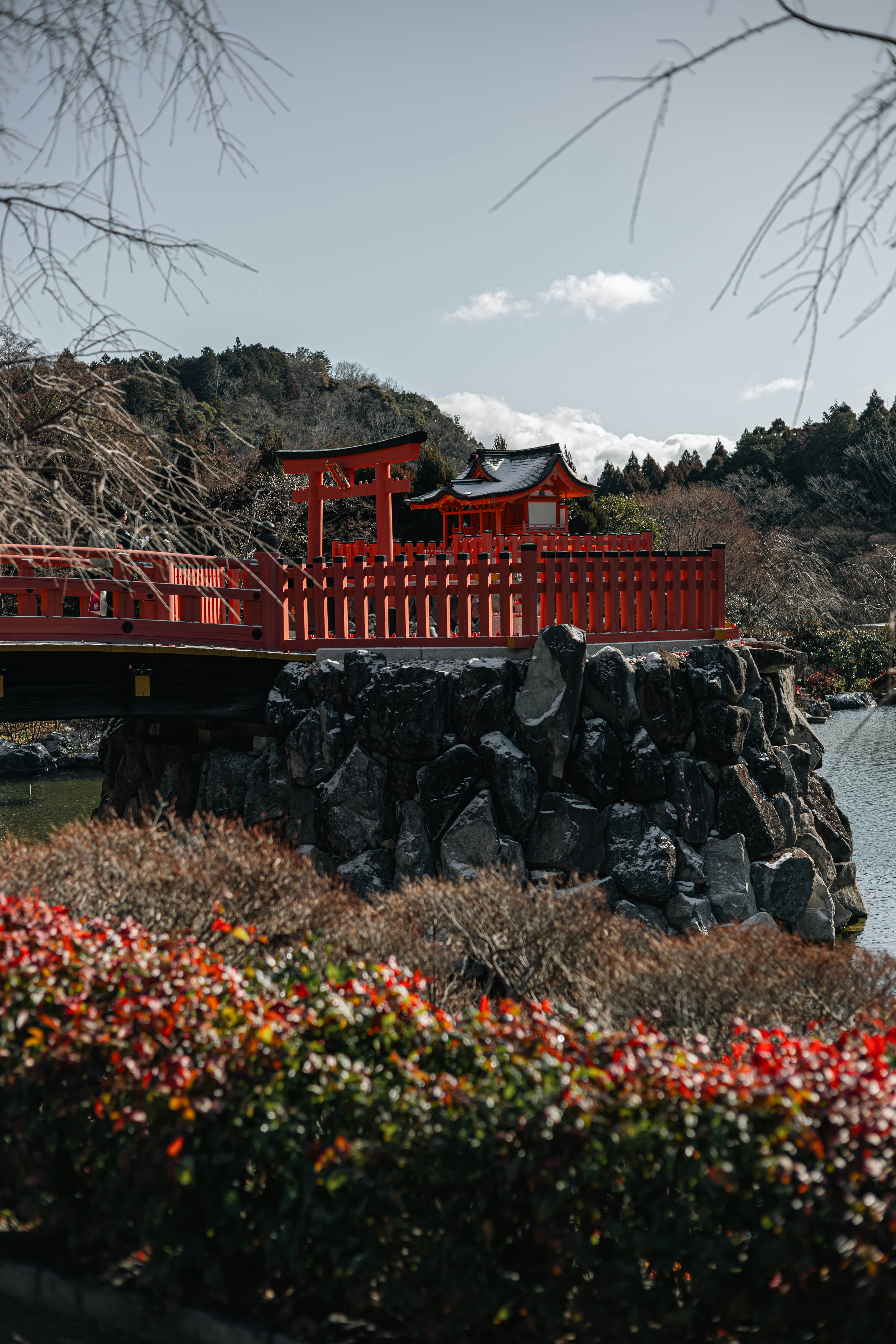 Crimson Shrine on the Lake: A Red Bridge Rising from Dark Stones