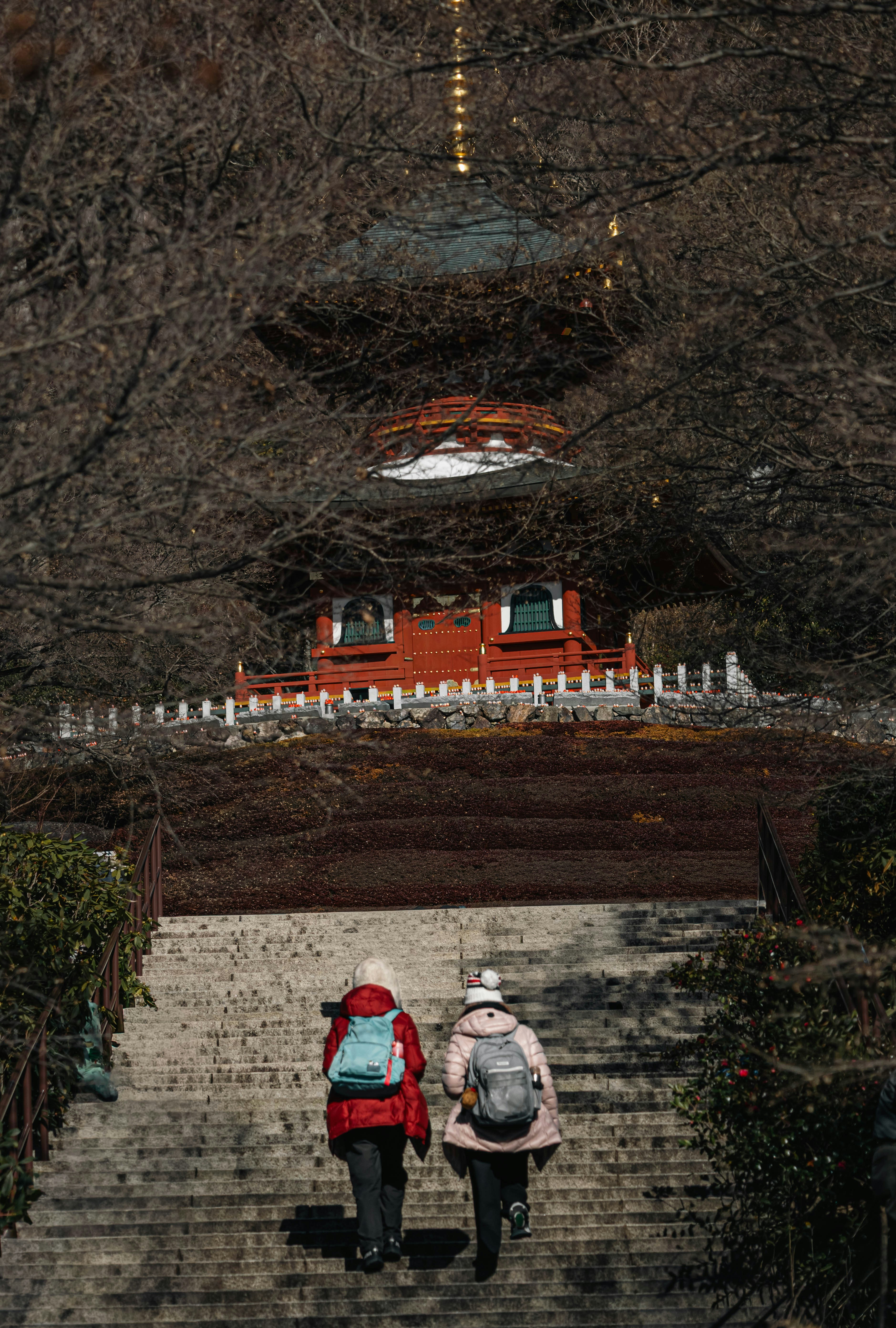 Red Gate in the Pines: Travelers Climb Toward a Lanterned Shrine