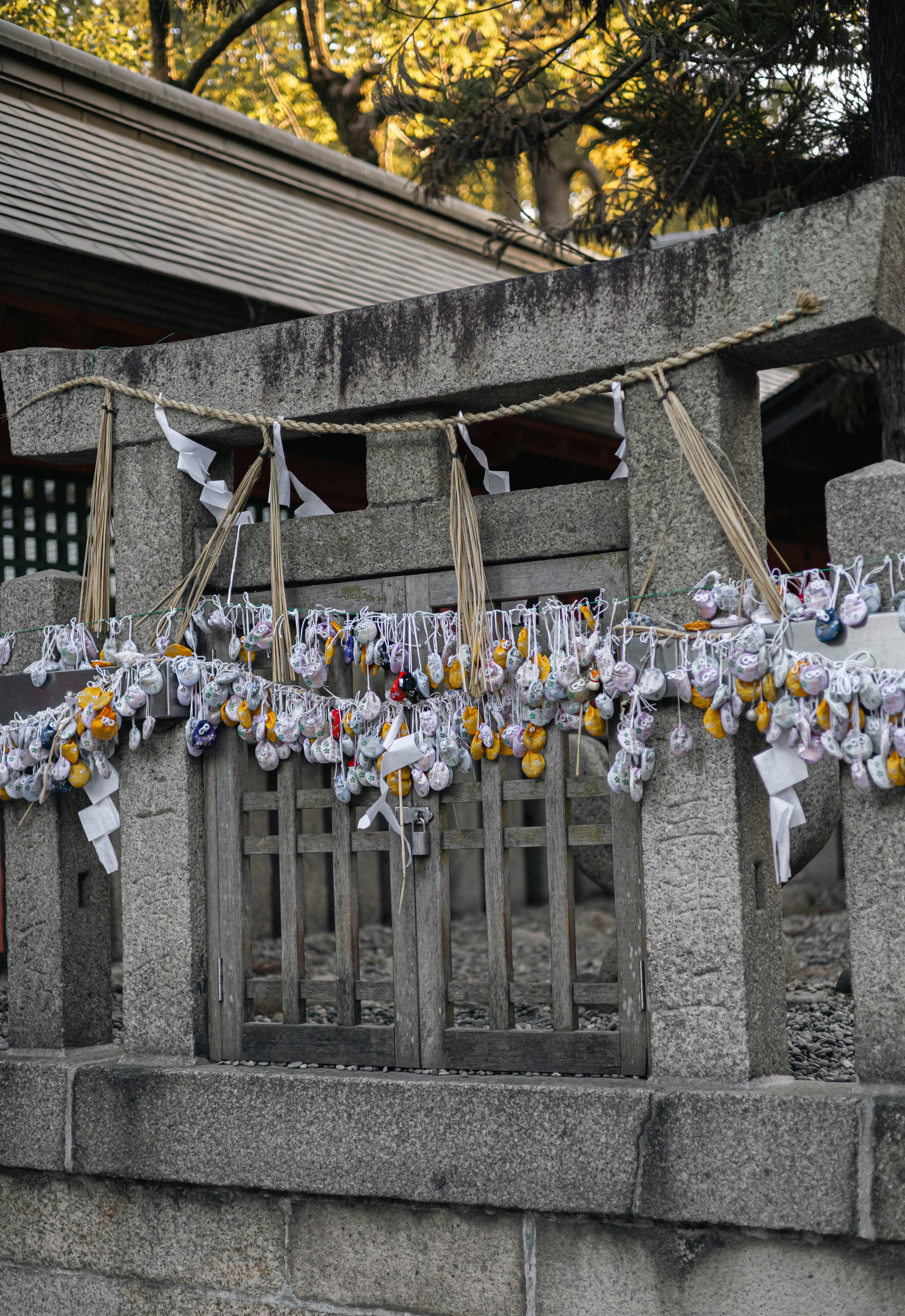 Prayer Ribbons Along the Stone Gate of a Shinto Shrine