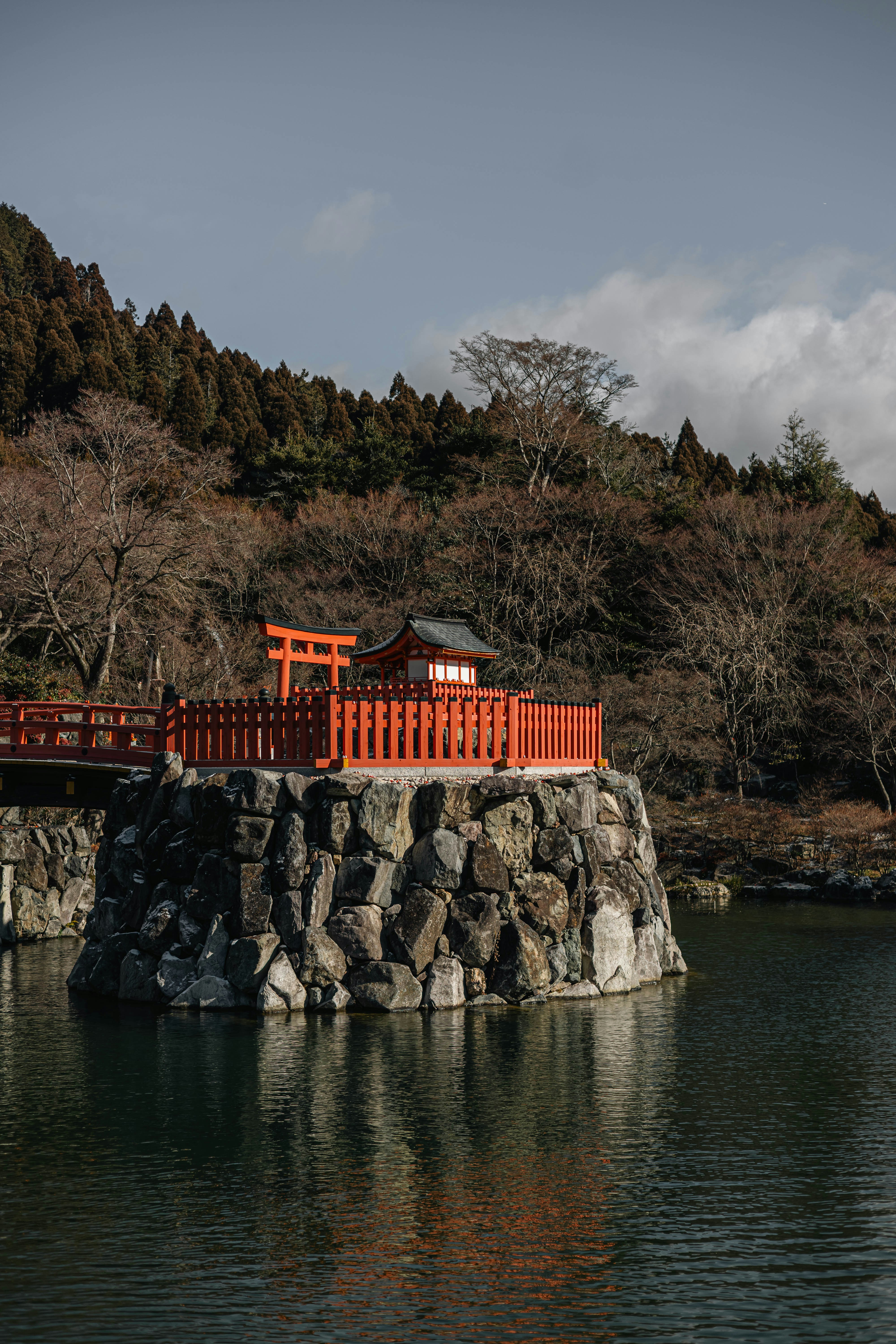 Red Bridge on a Stone Island: A Tranquil Shrine Overlooking Water
