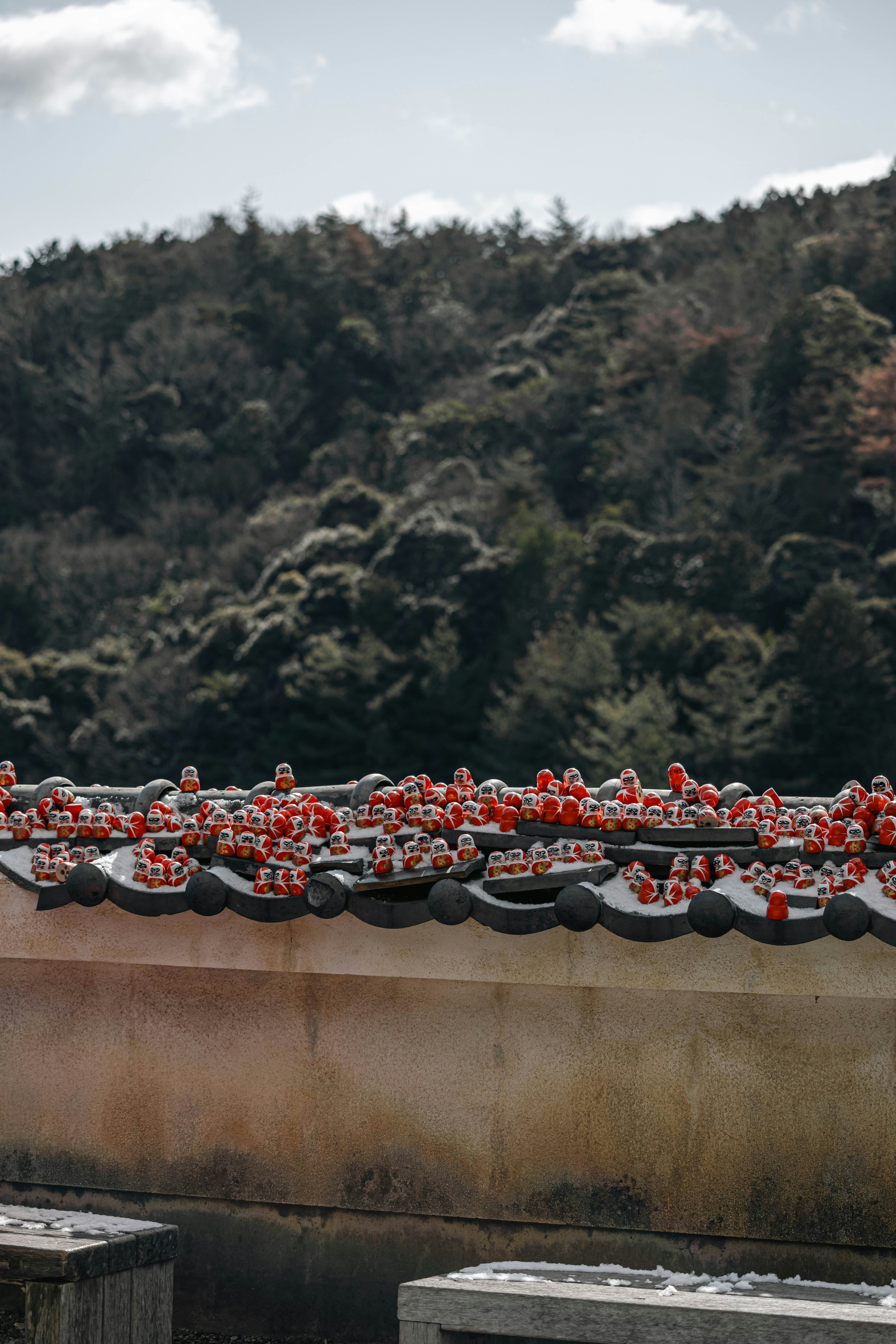 Row upon row of tiny red-hooded figures lining a tiled wall