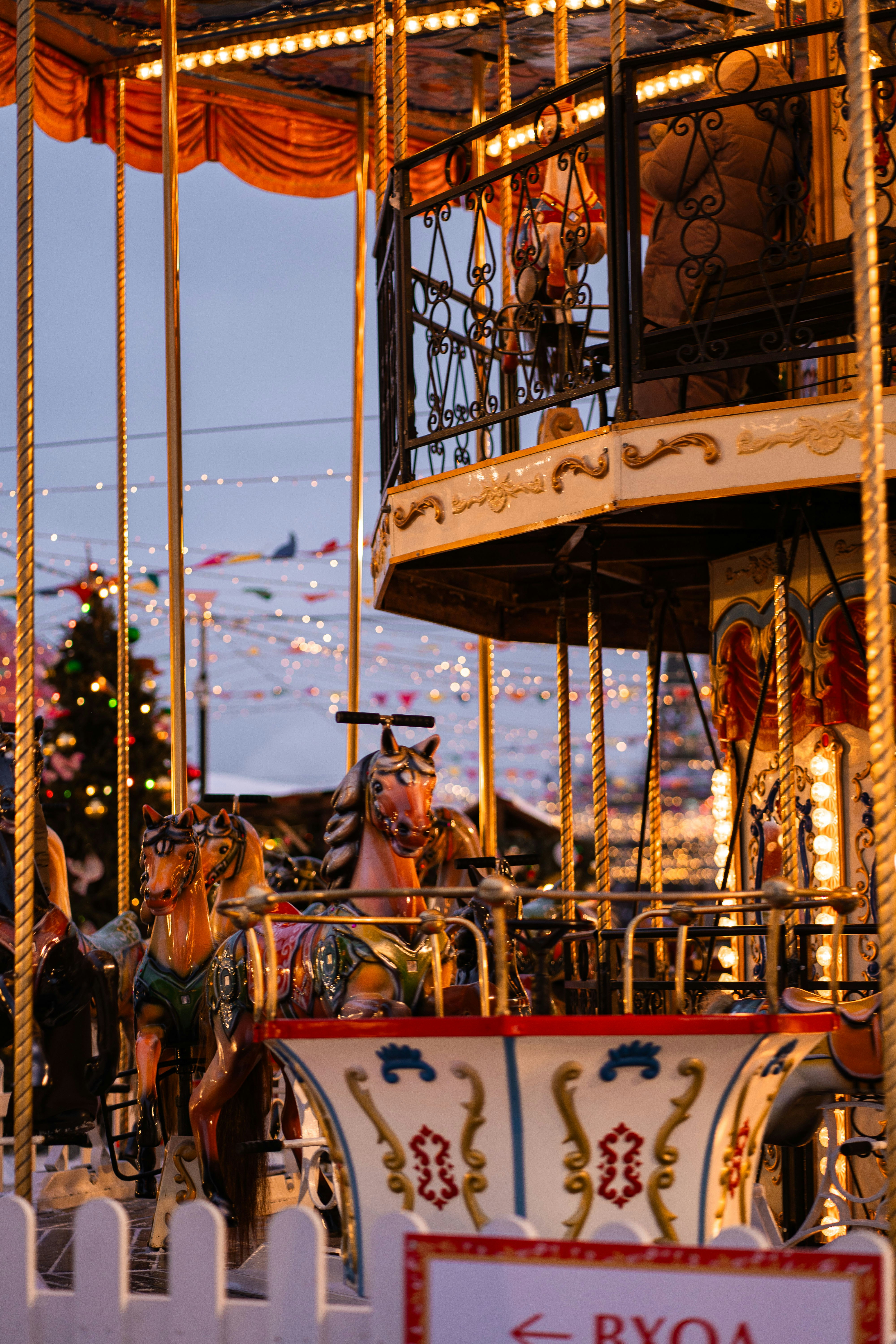 Glowing Carousel at Dusk: Horses in Motion and Ornate Carriage