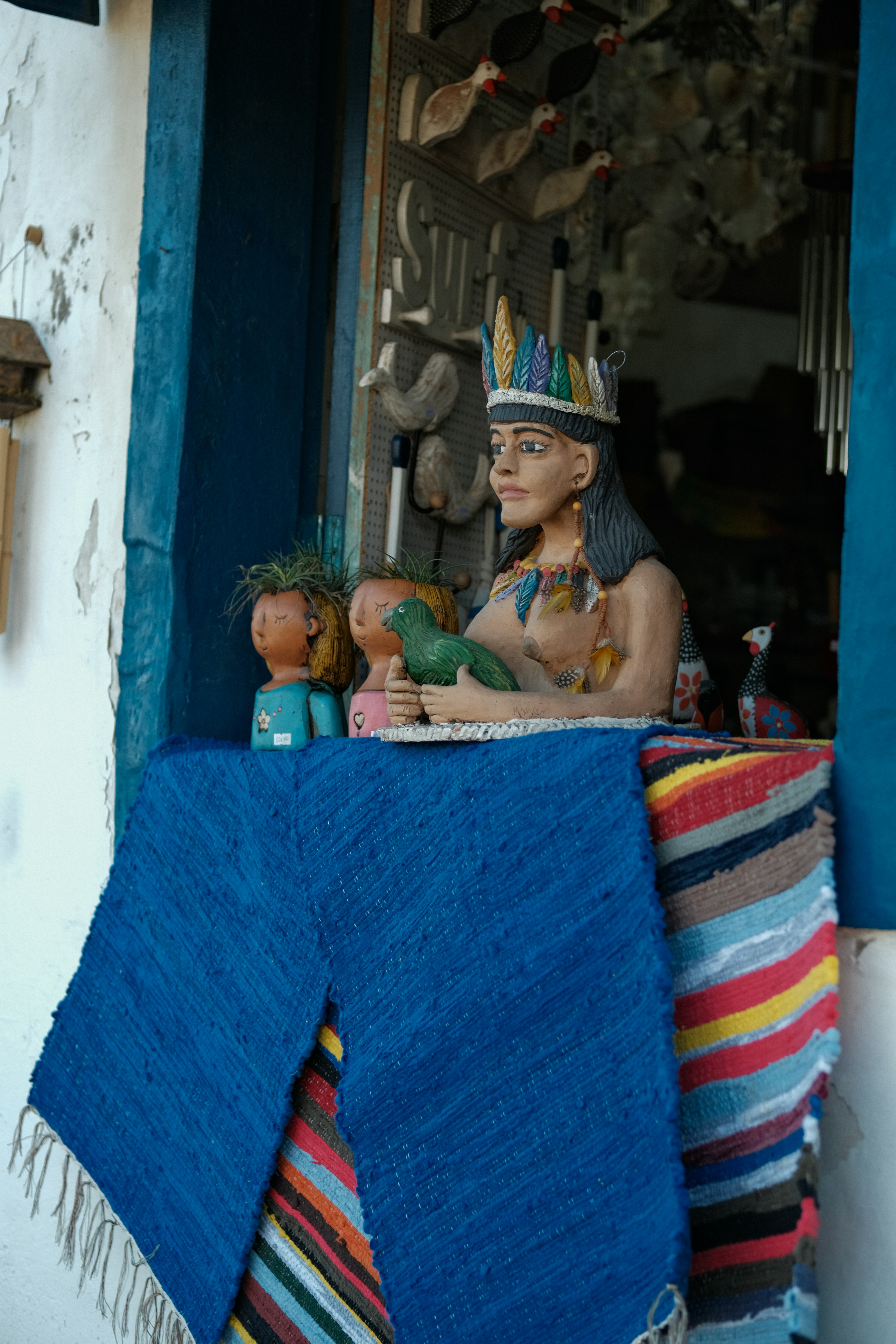 Colorful Native Figurine Studio Window with Blue Textile Drapery
