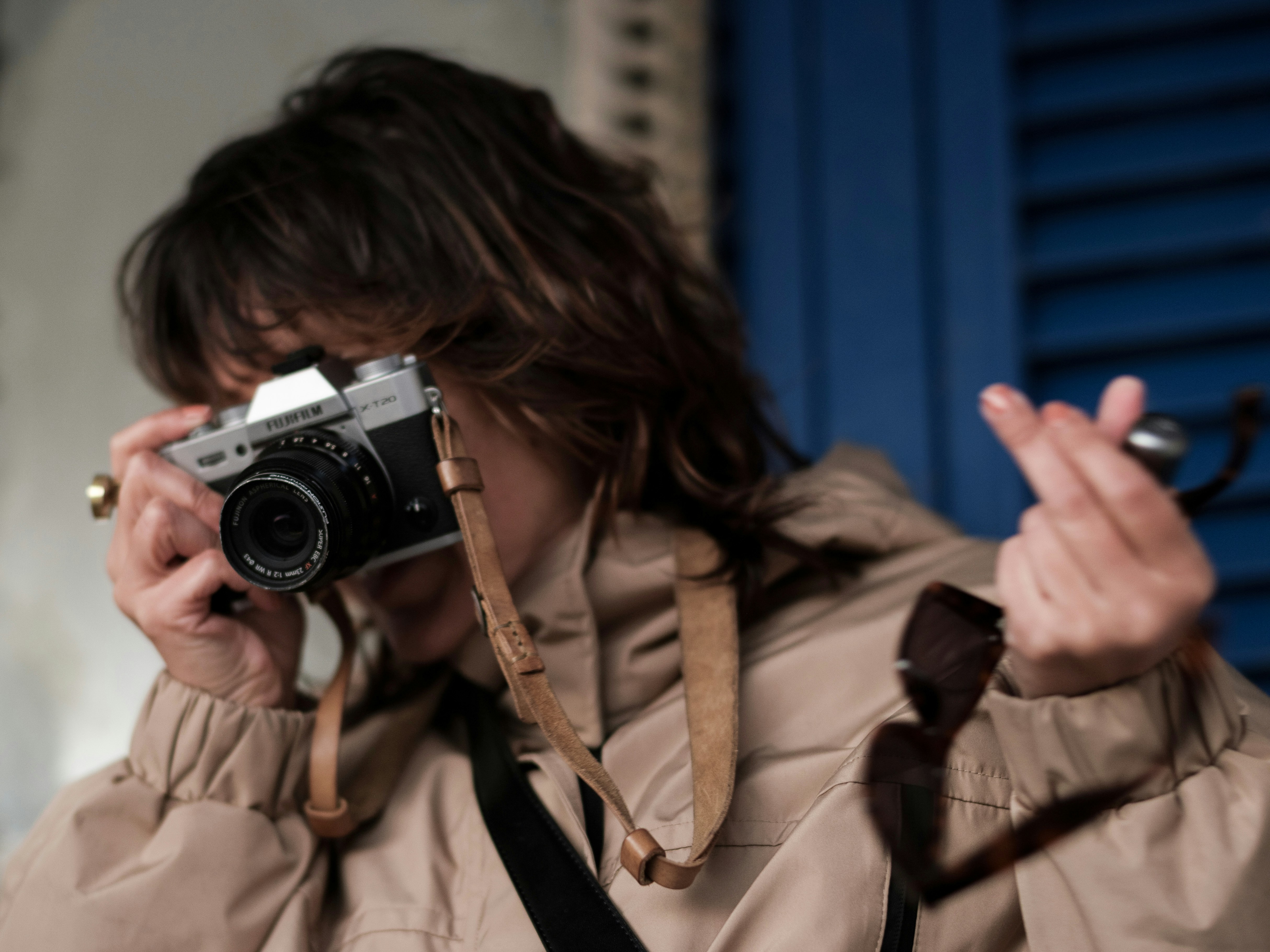 Portrait in Motion: A candid street photographer mid-gestures with vintage camera