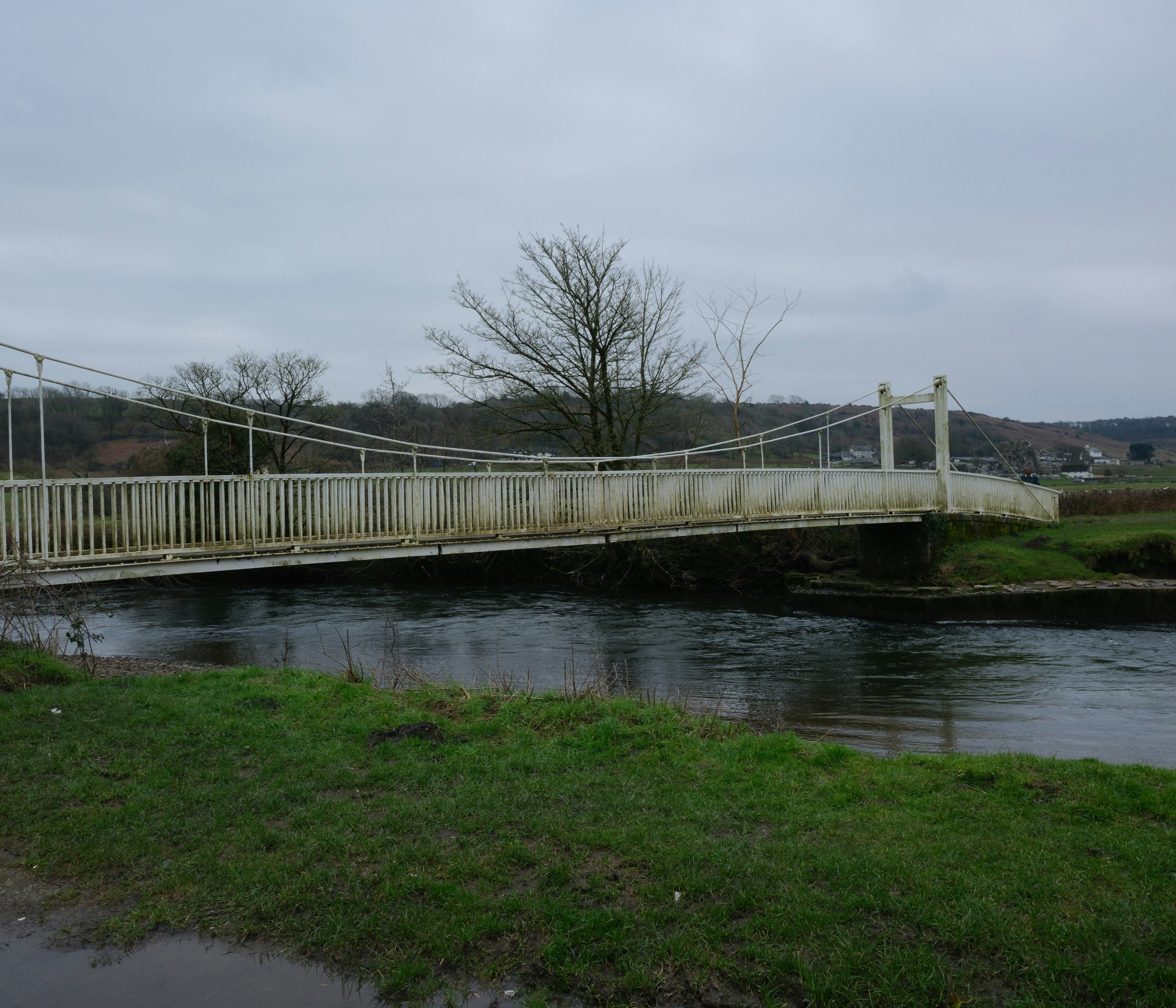 Suspended Path Over Quiet River: A Gray Day by the Bridge