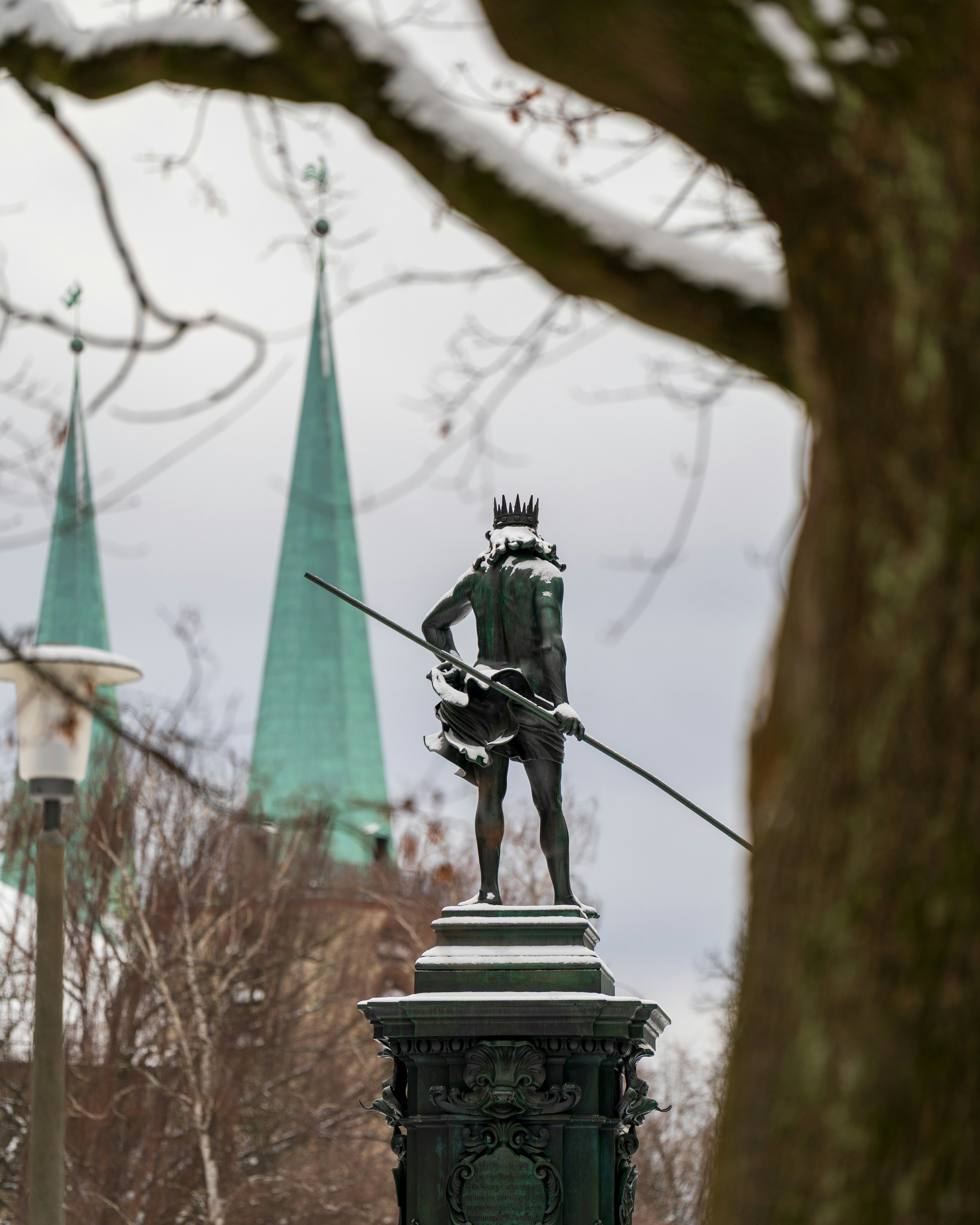 Spear and Shadow: A Monumental Figure Framed by Cathedral Towers