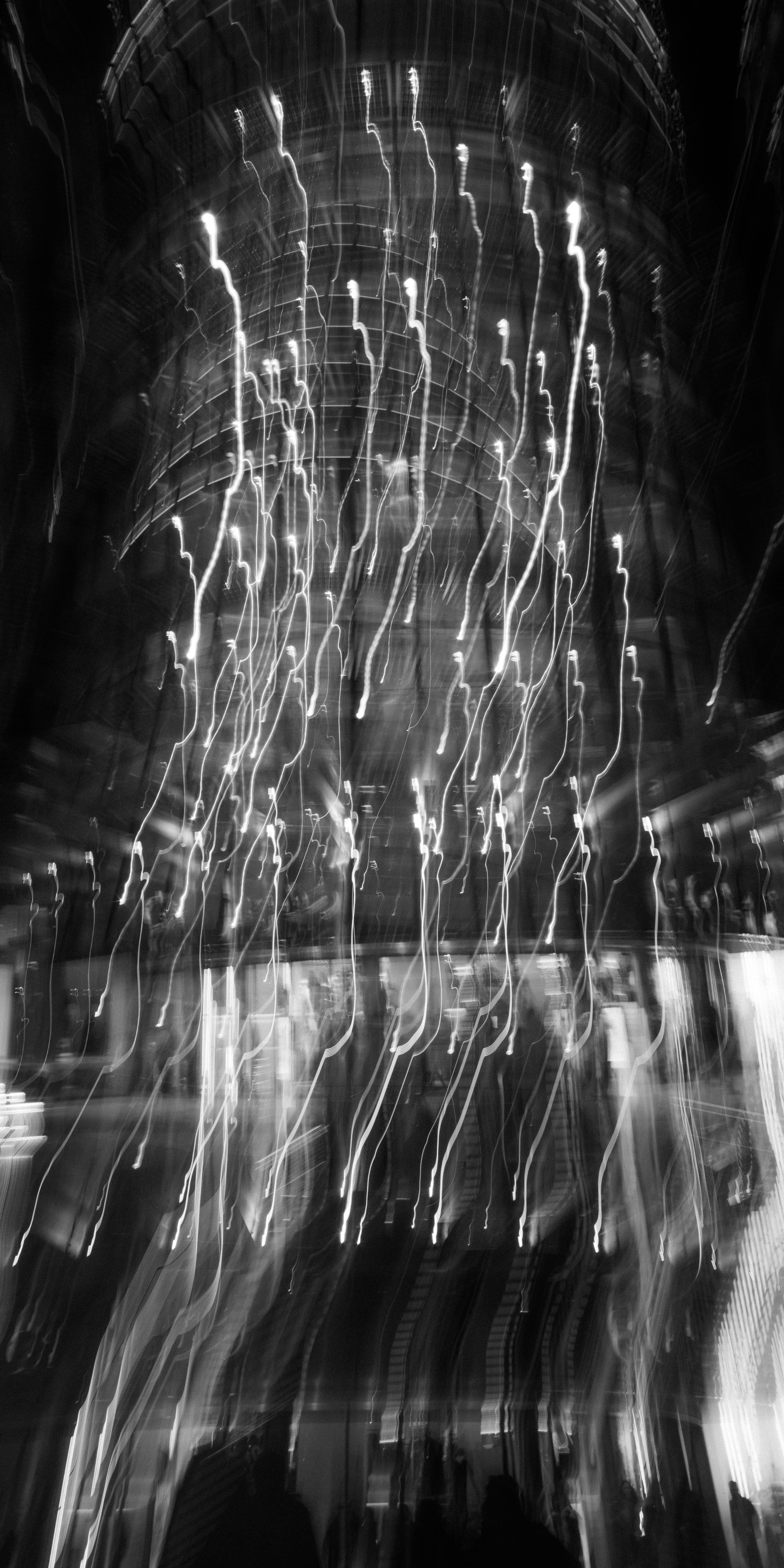 Luminous Traces: Nighttime Spiral Through a Glass Atrium