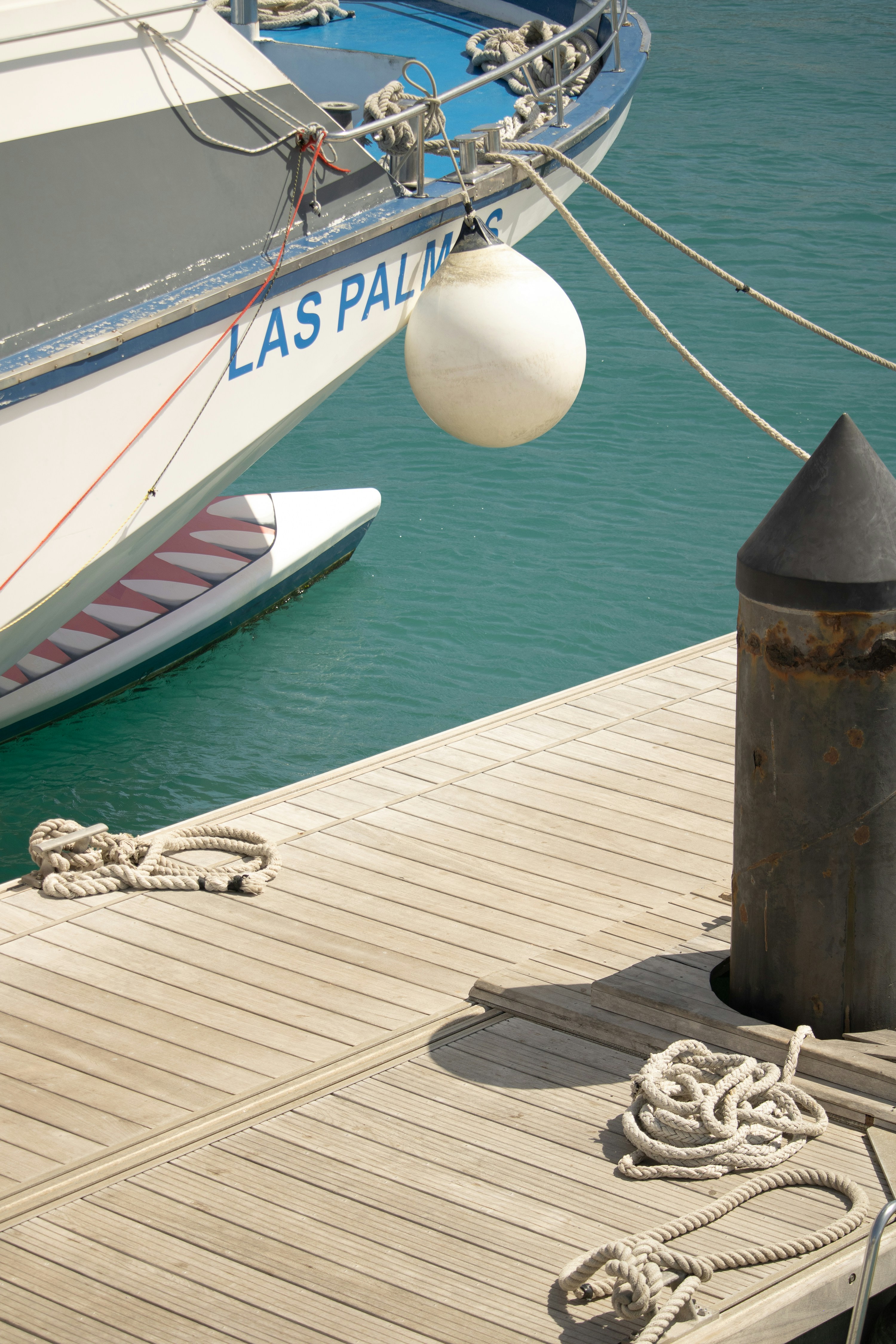 Dockside Vessel: A Hull, Ropes, and Teal Water