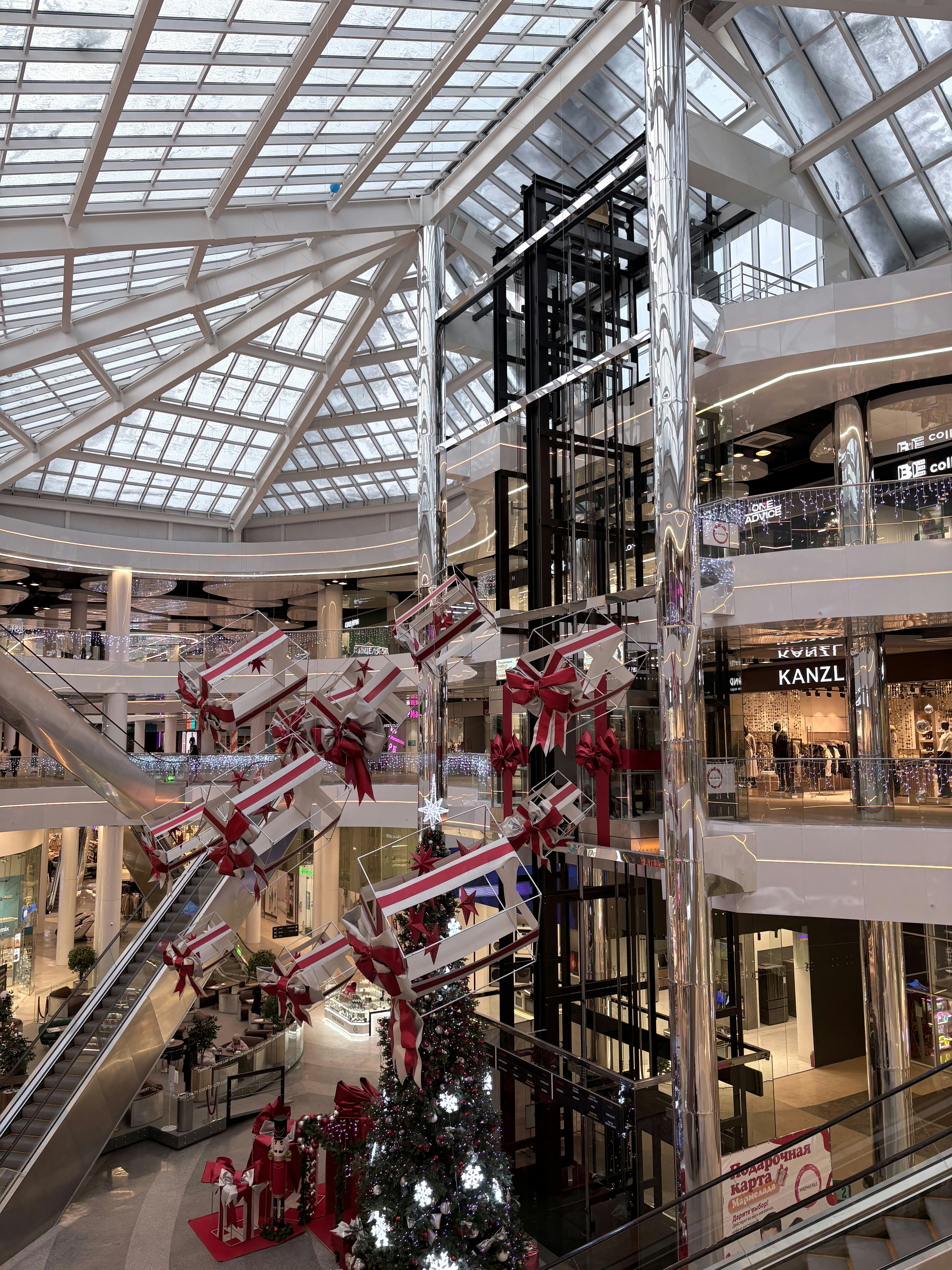 A gleaming atrium wrapped in glass and festive décor