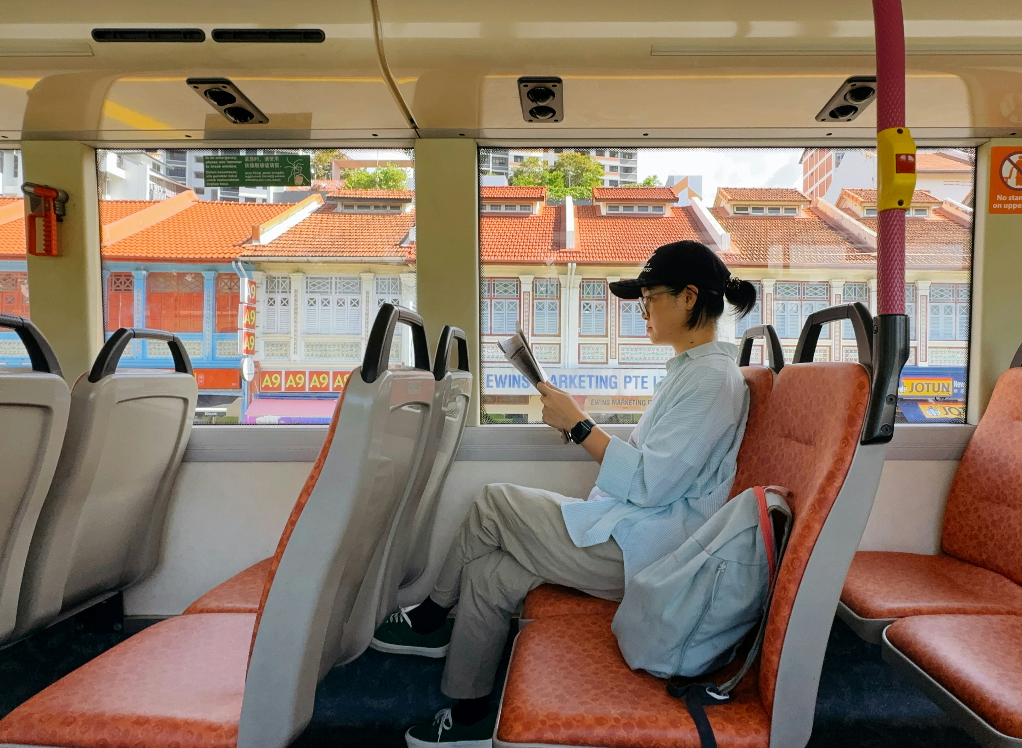 Solo passenger in an urban bus glances at a handheld device