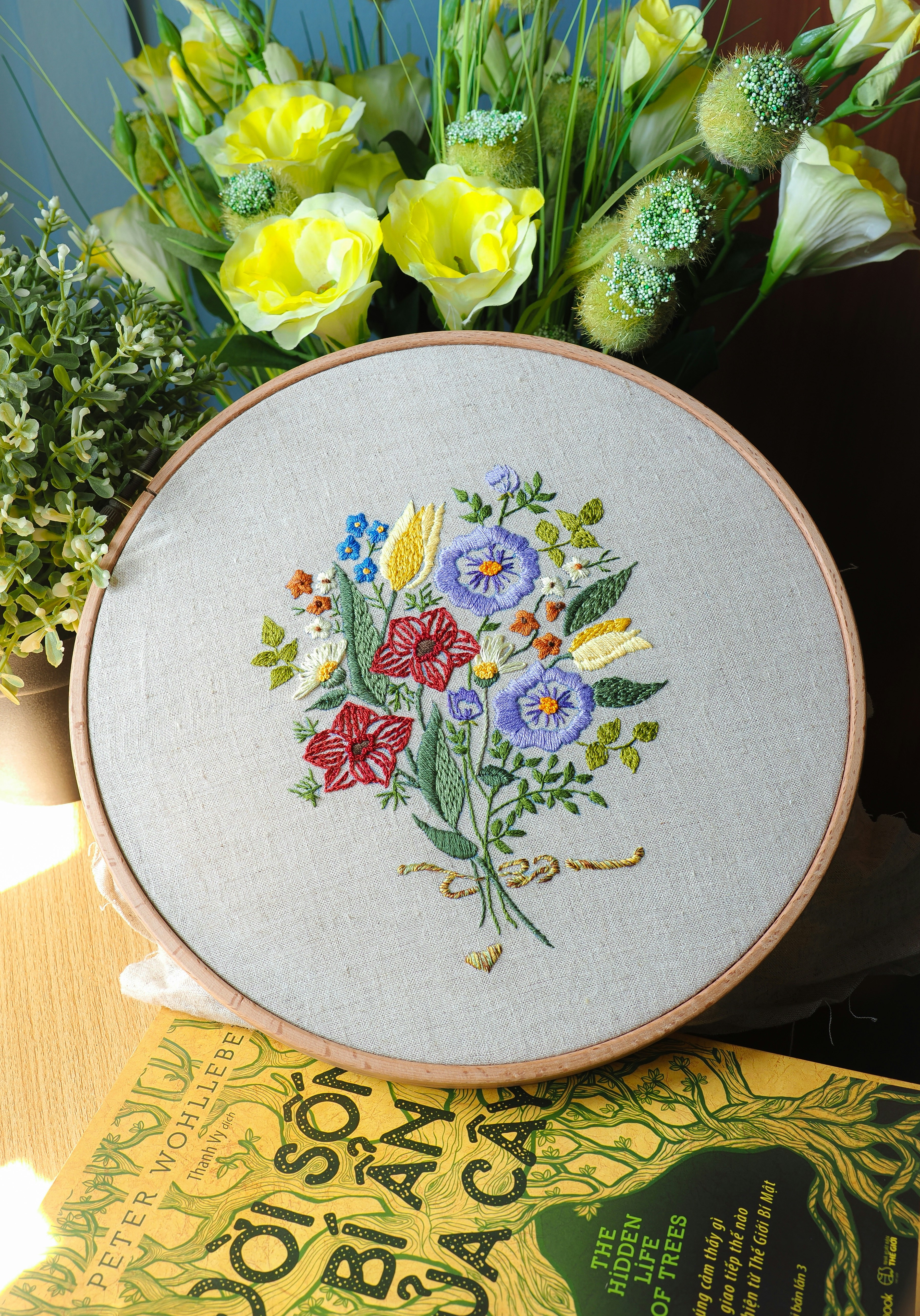 Threaded Bouquet: Embroidered Floral Centerpiece Amidst Sunlit Still Life
