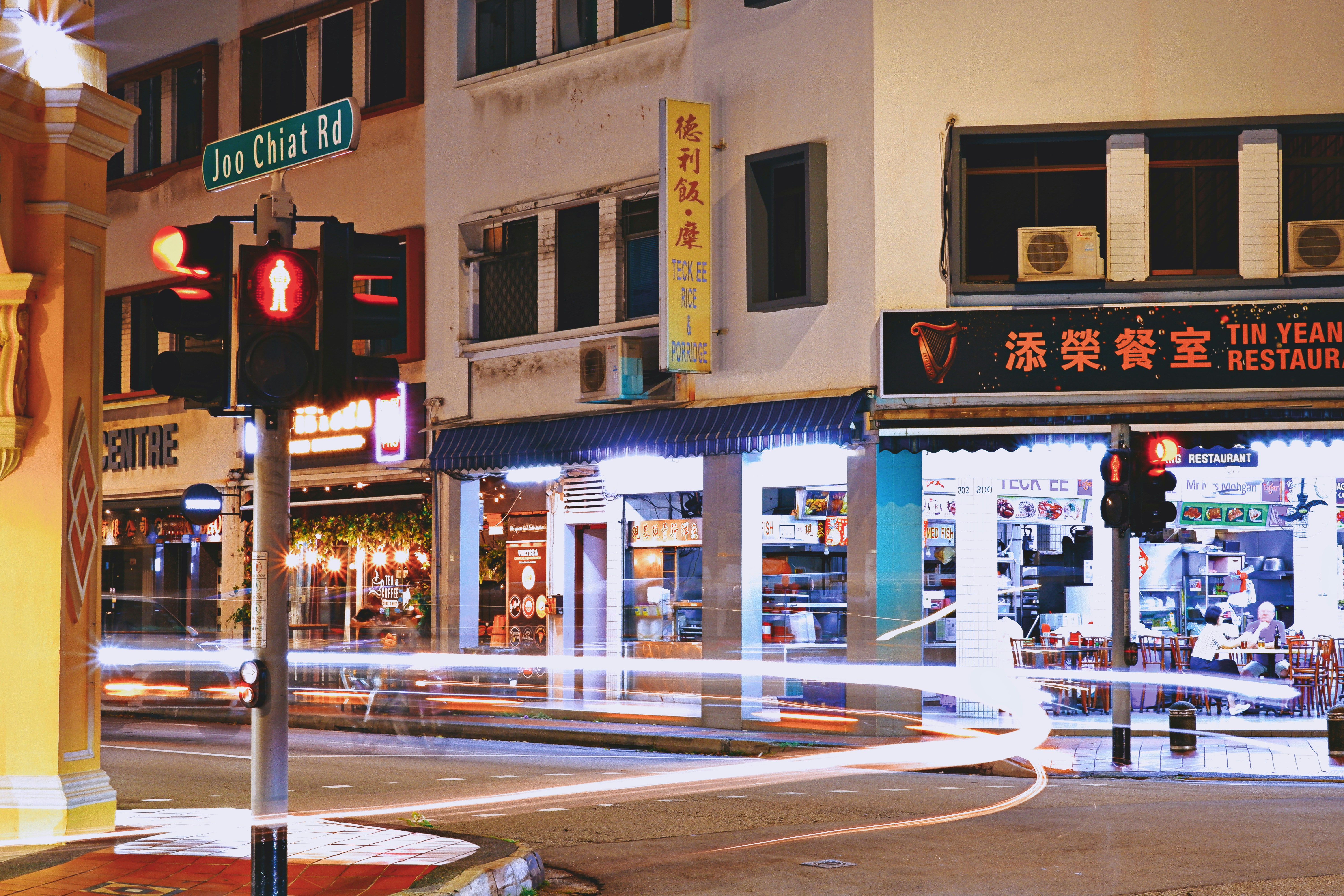 Neon Street Pulse: A Blur of Motion Under a Red Signal