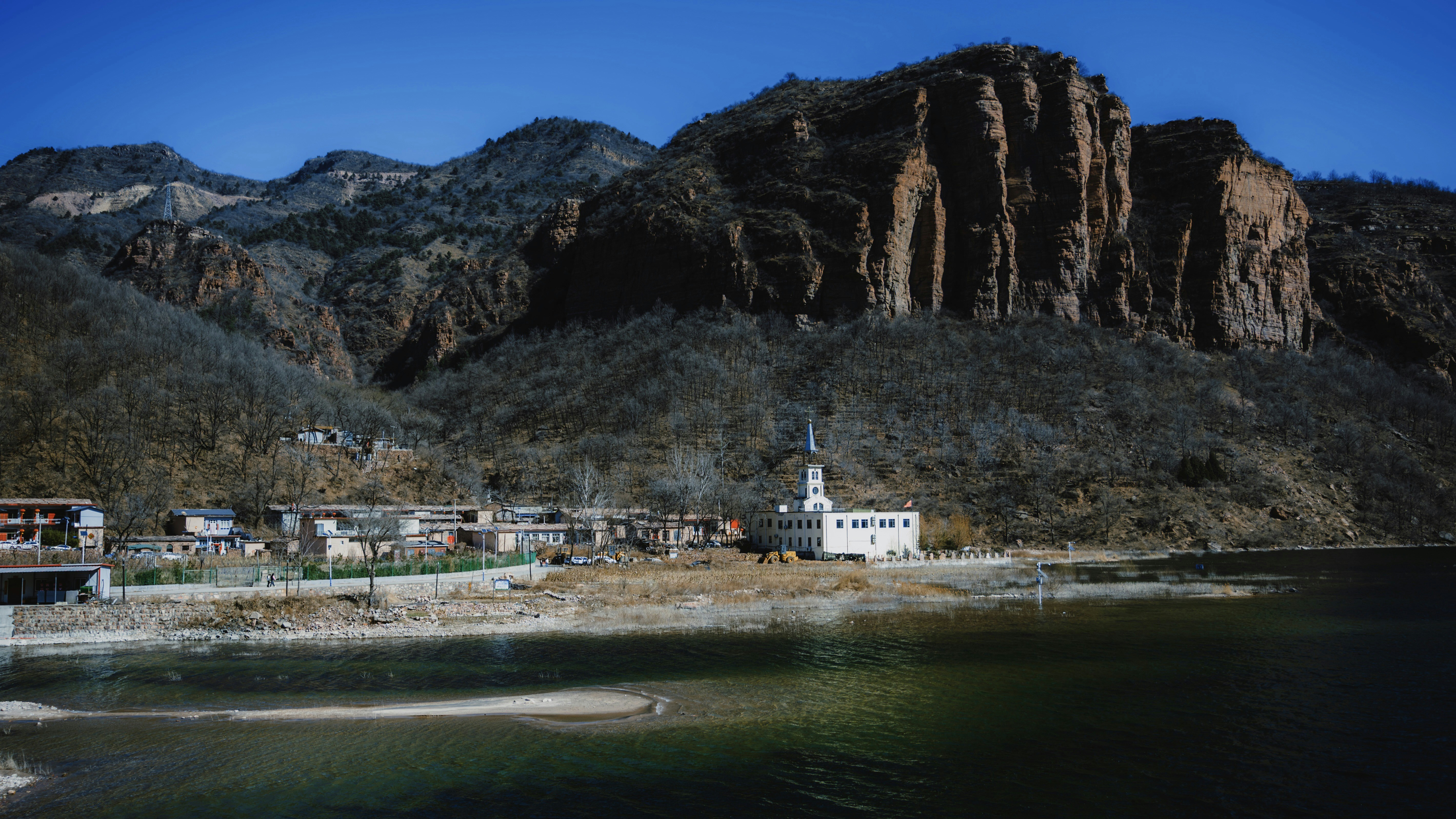 Rugged Hills Meet Quiet Harbor: A Riverscape at Dusk