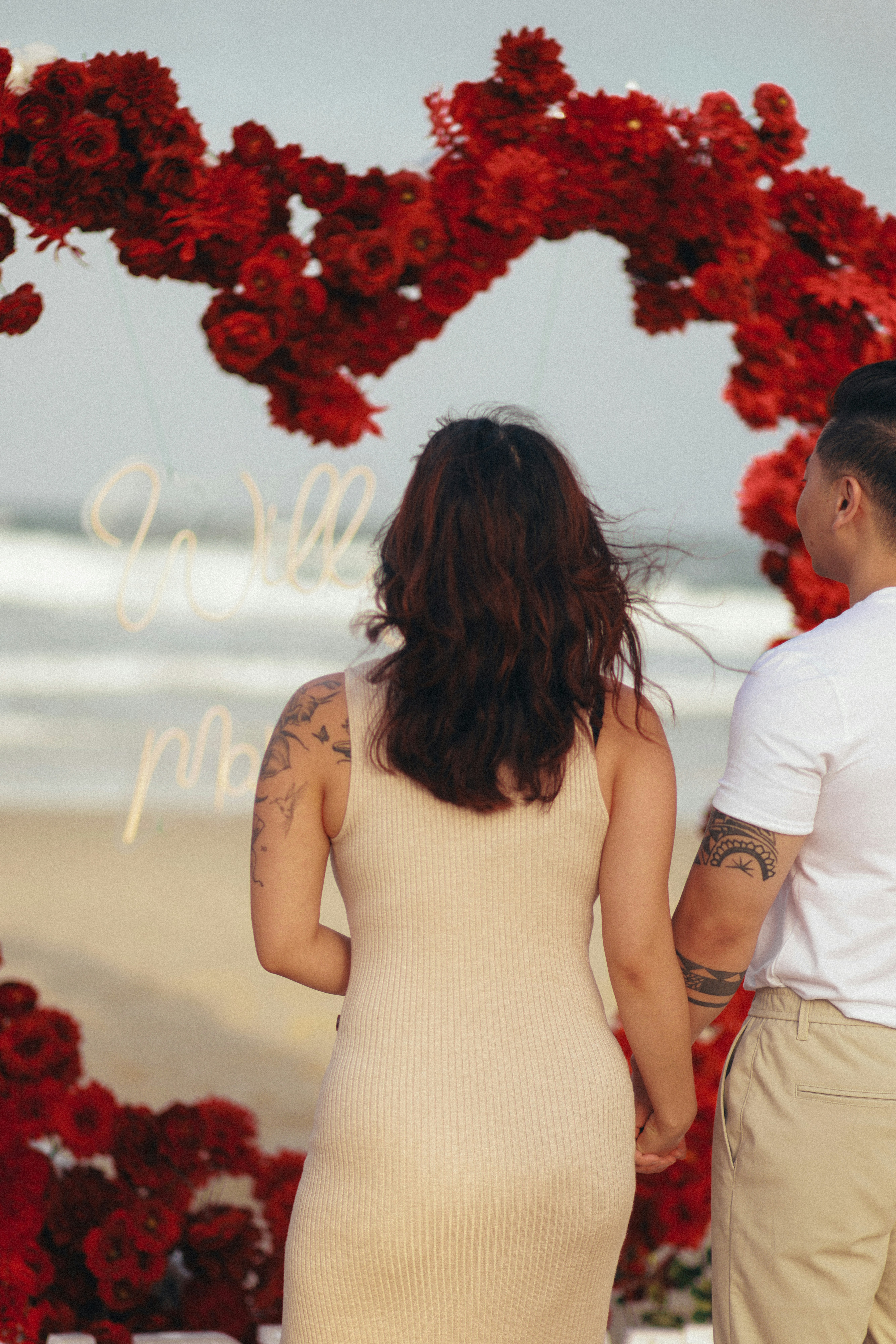 Couple in a Red-Floraled Arch at the Beach