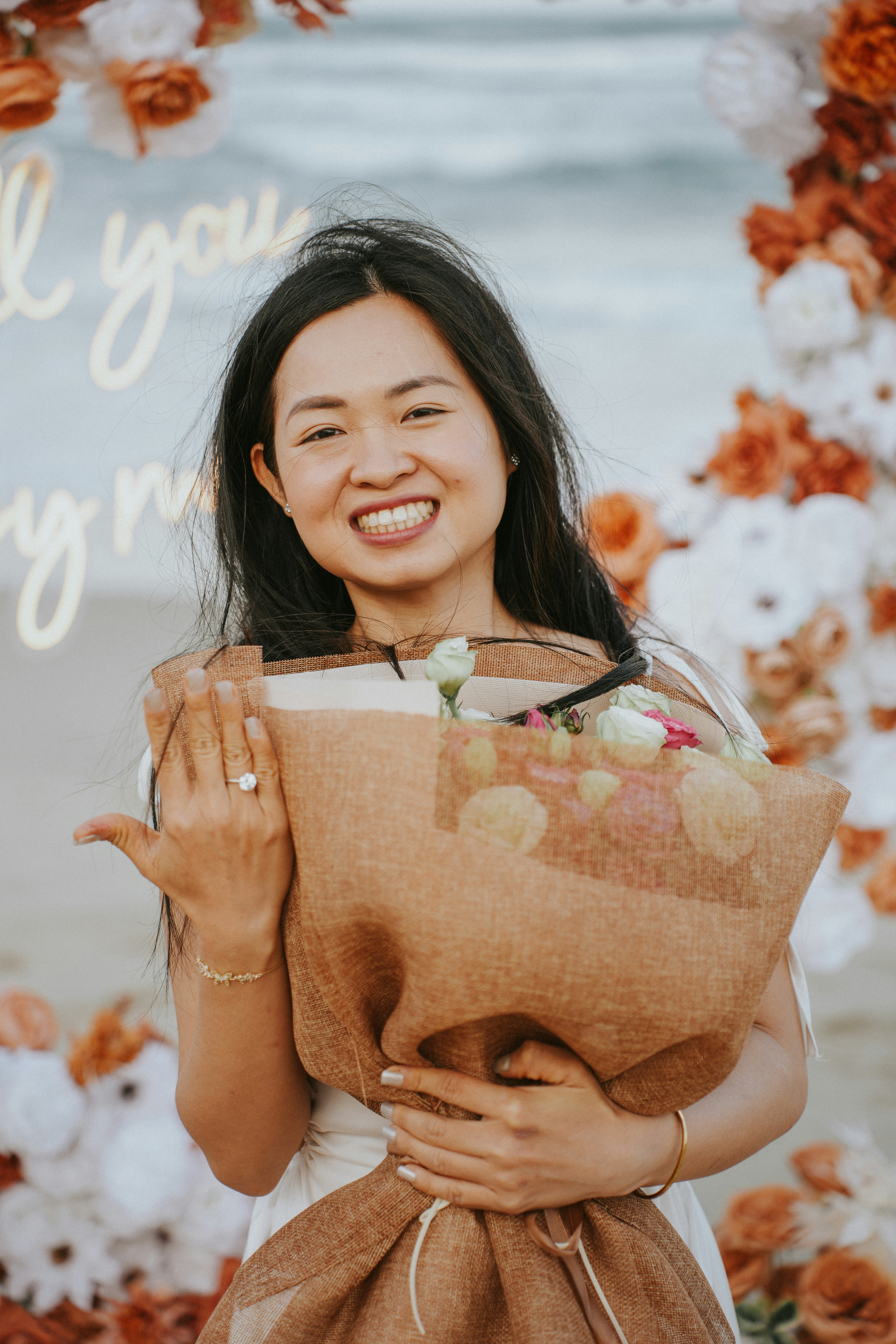 Bouquet of Joy: A Bride-To-Be Amid Florals and Soft Beach Light