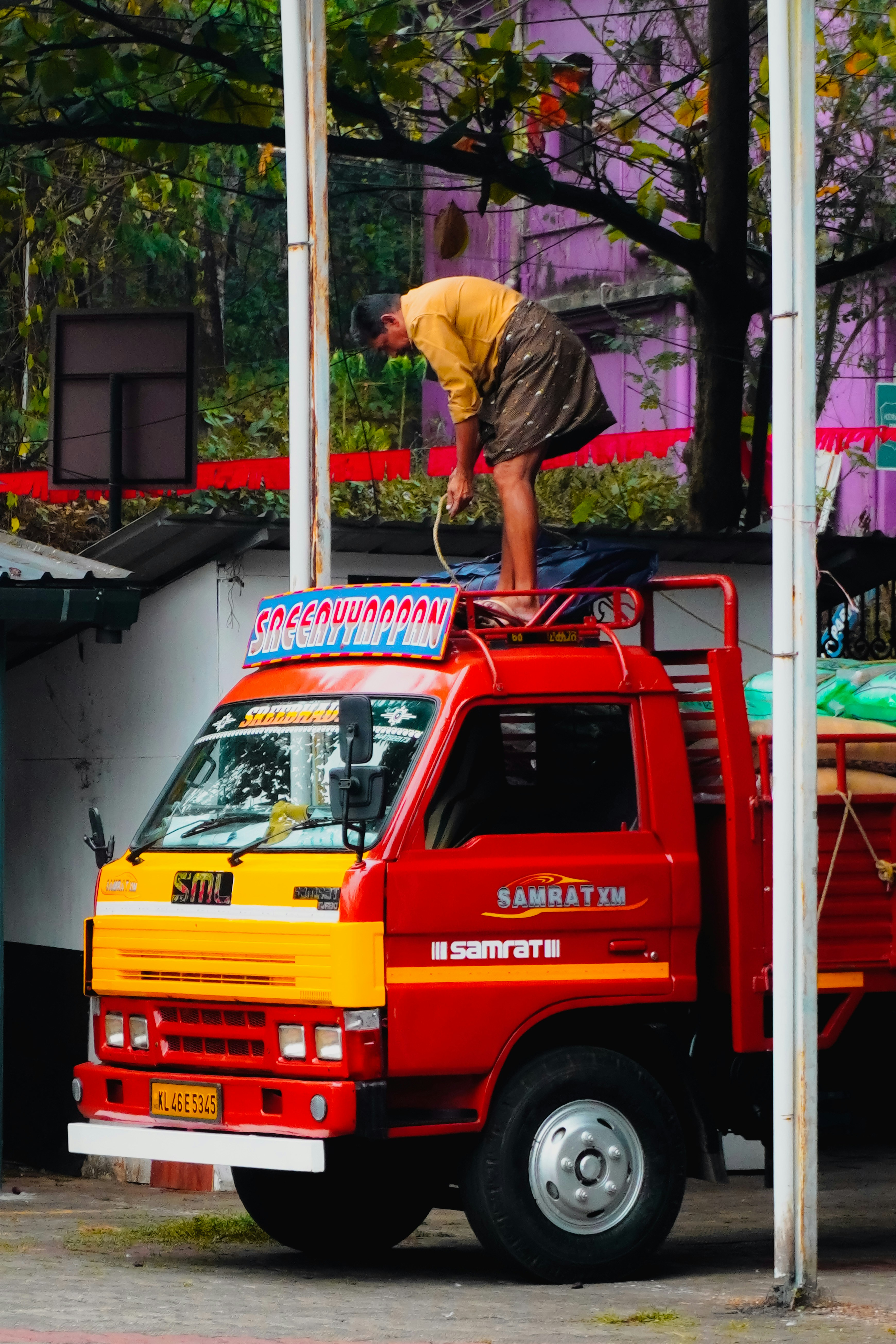 Red Freight: Worker on a Lifting Dawn amid a Bright Truck