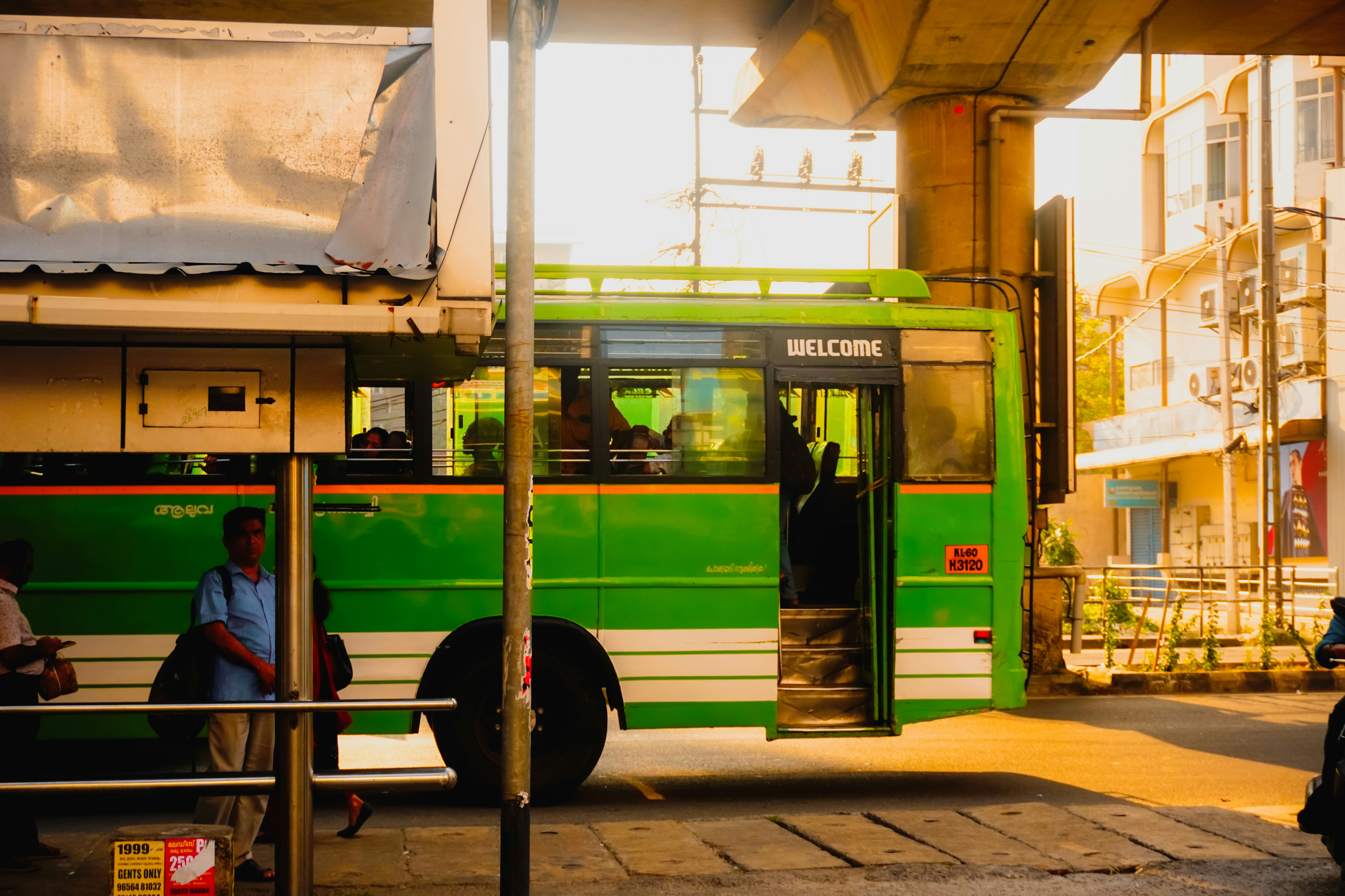 Green Transit at Dusk: A Quiet Bus Stop Behind the Rail Overpass