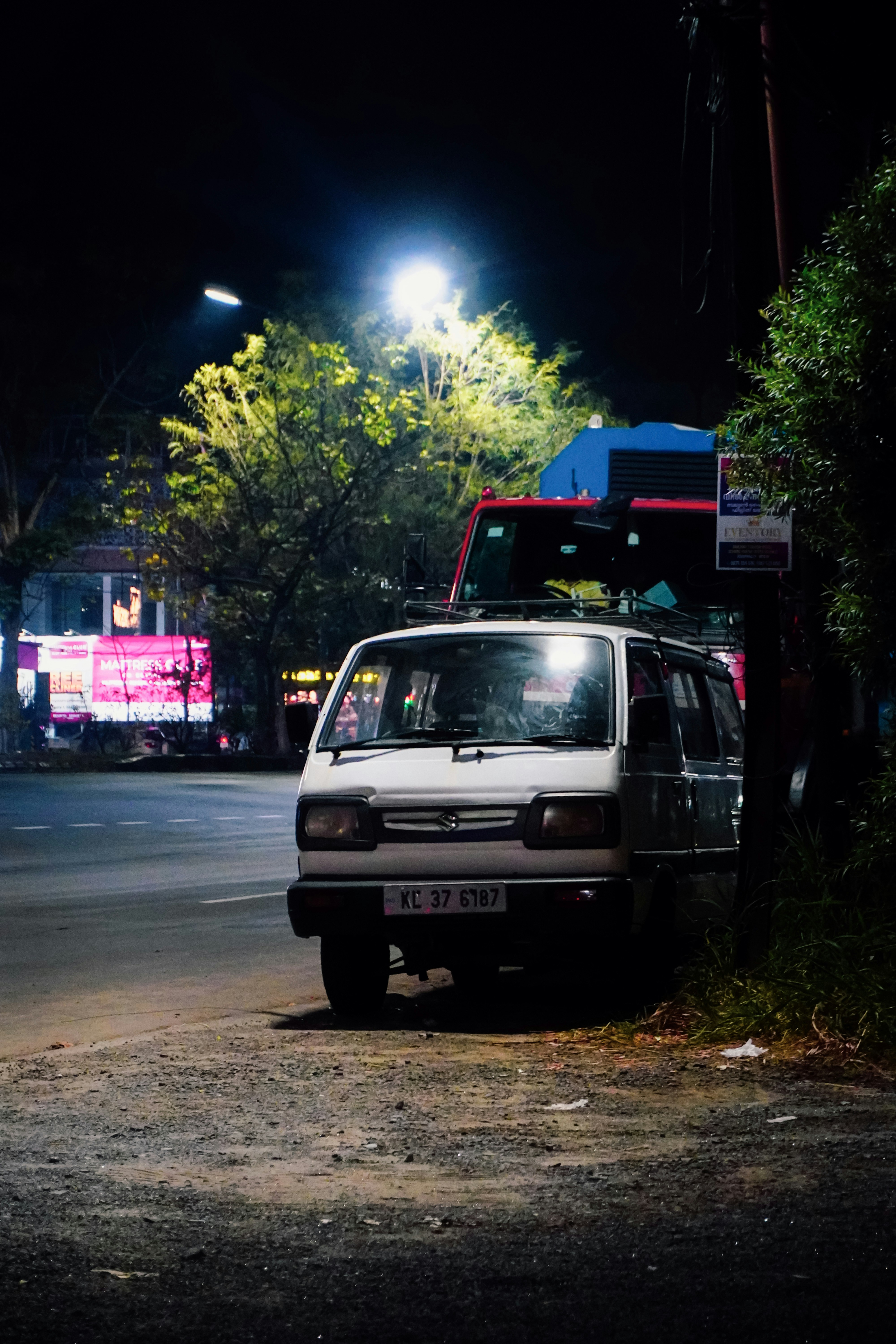 Night Bus Stop: A White Van Under Urban Neon Lights