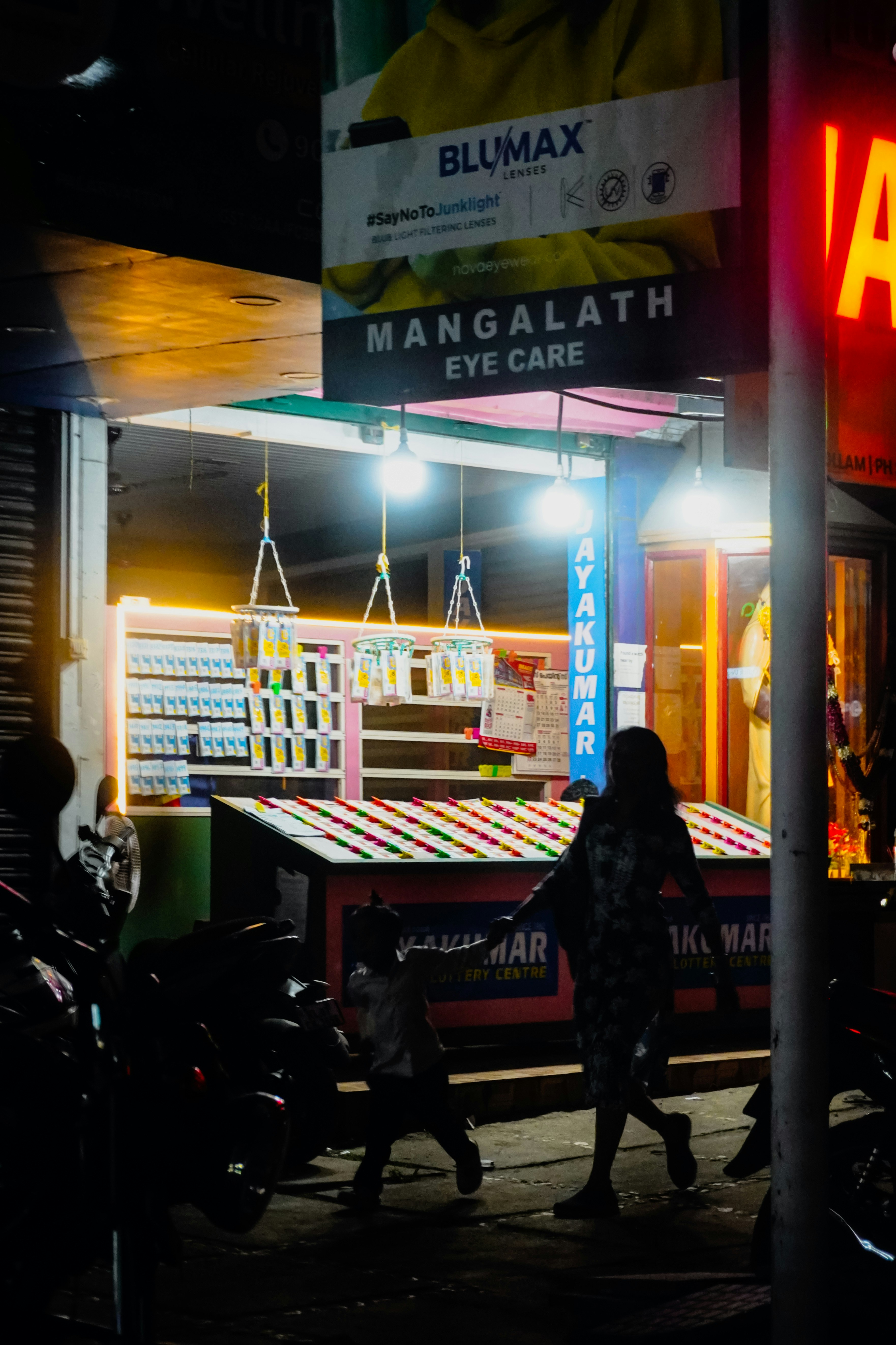Neon Night Walk: Shadowed Silhouettes at a Bustling Tienda