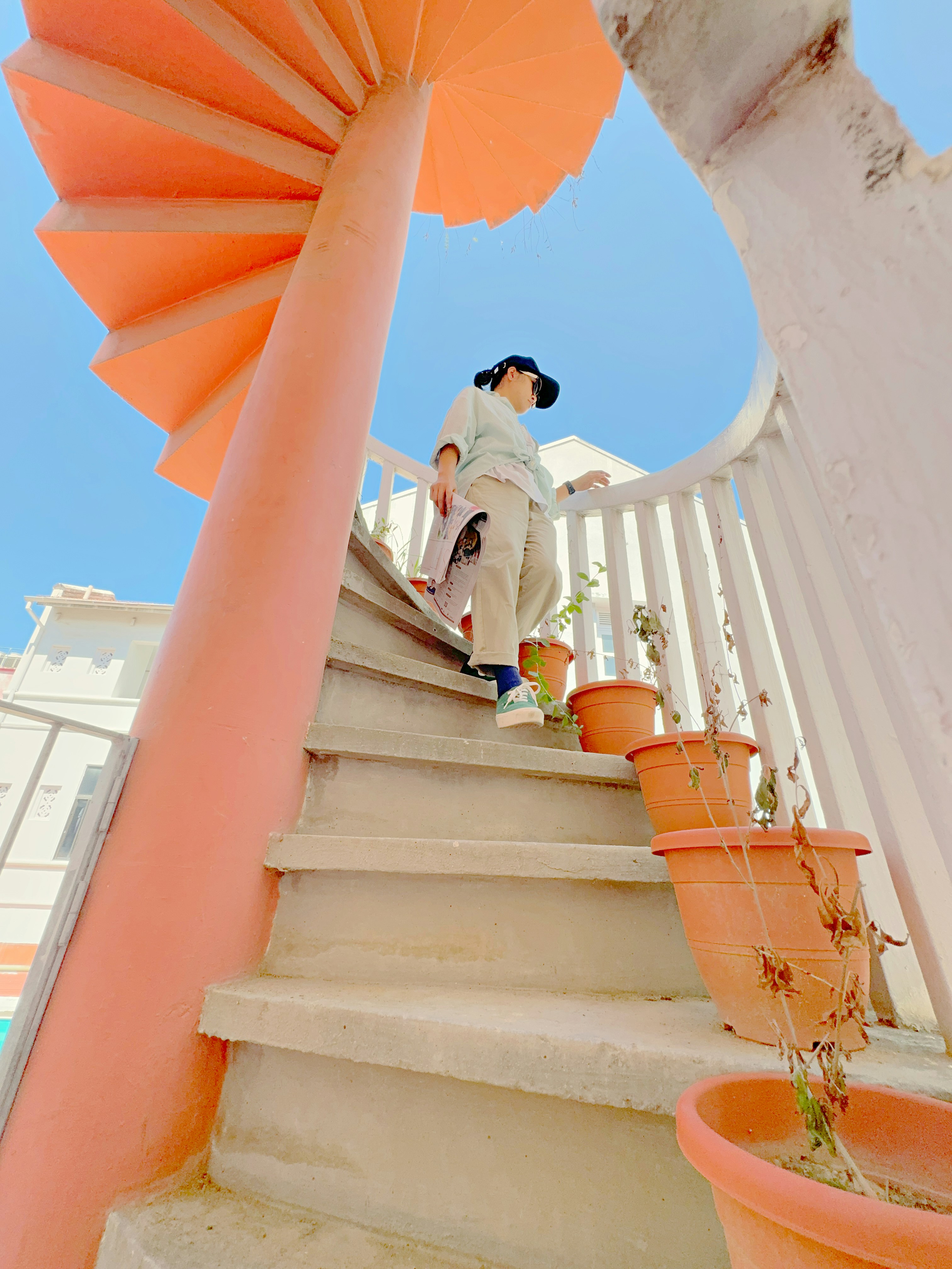 Ascending under the Coral Spiral: A Child on the Staircase of Sunlit Terracotta